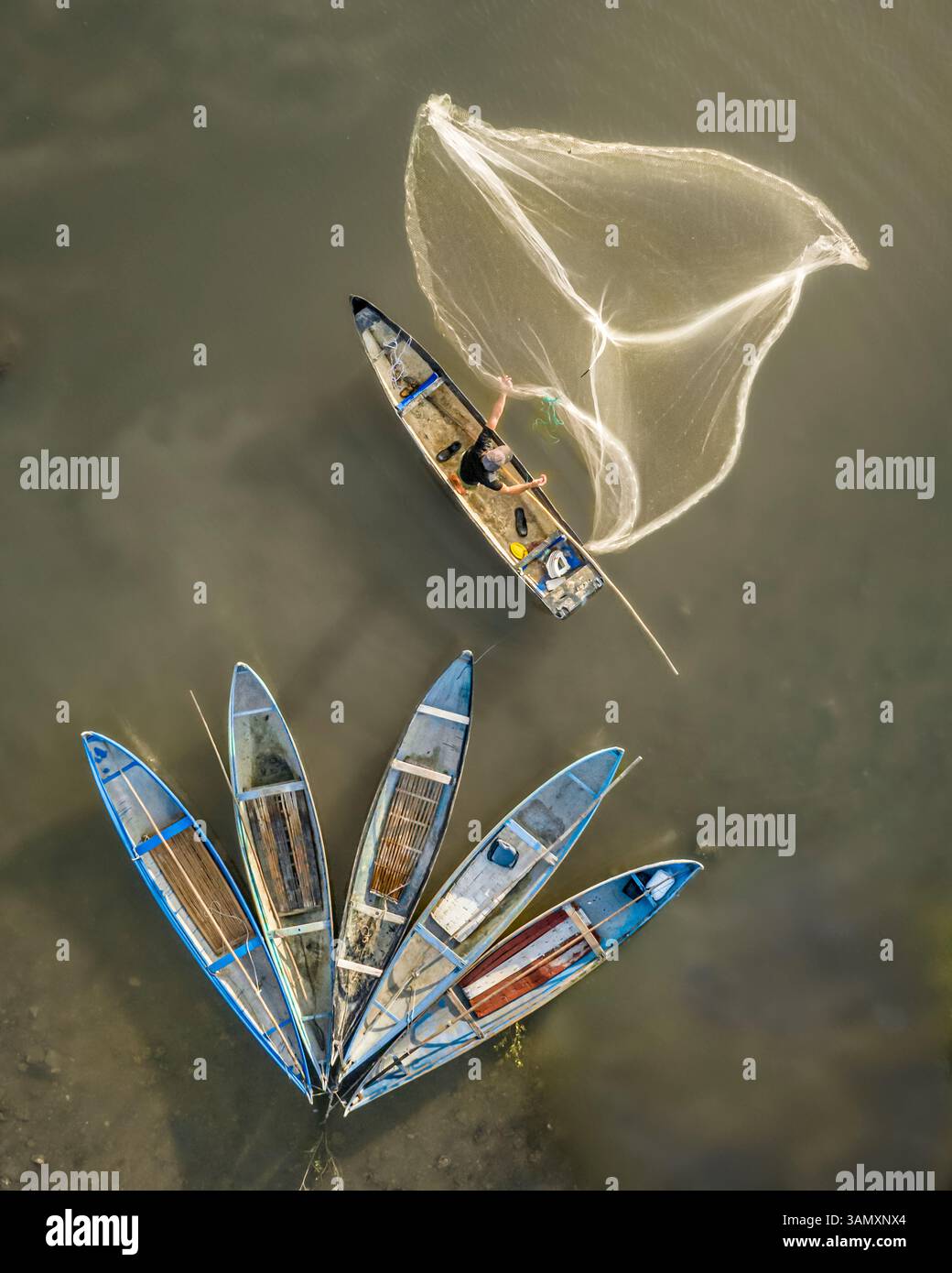 Aerial view of fishermen casting star shaped nets from wooden boats in ...