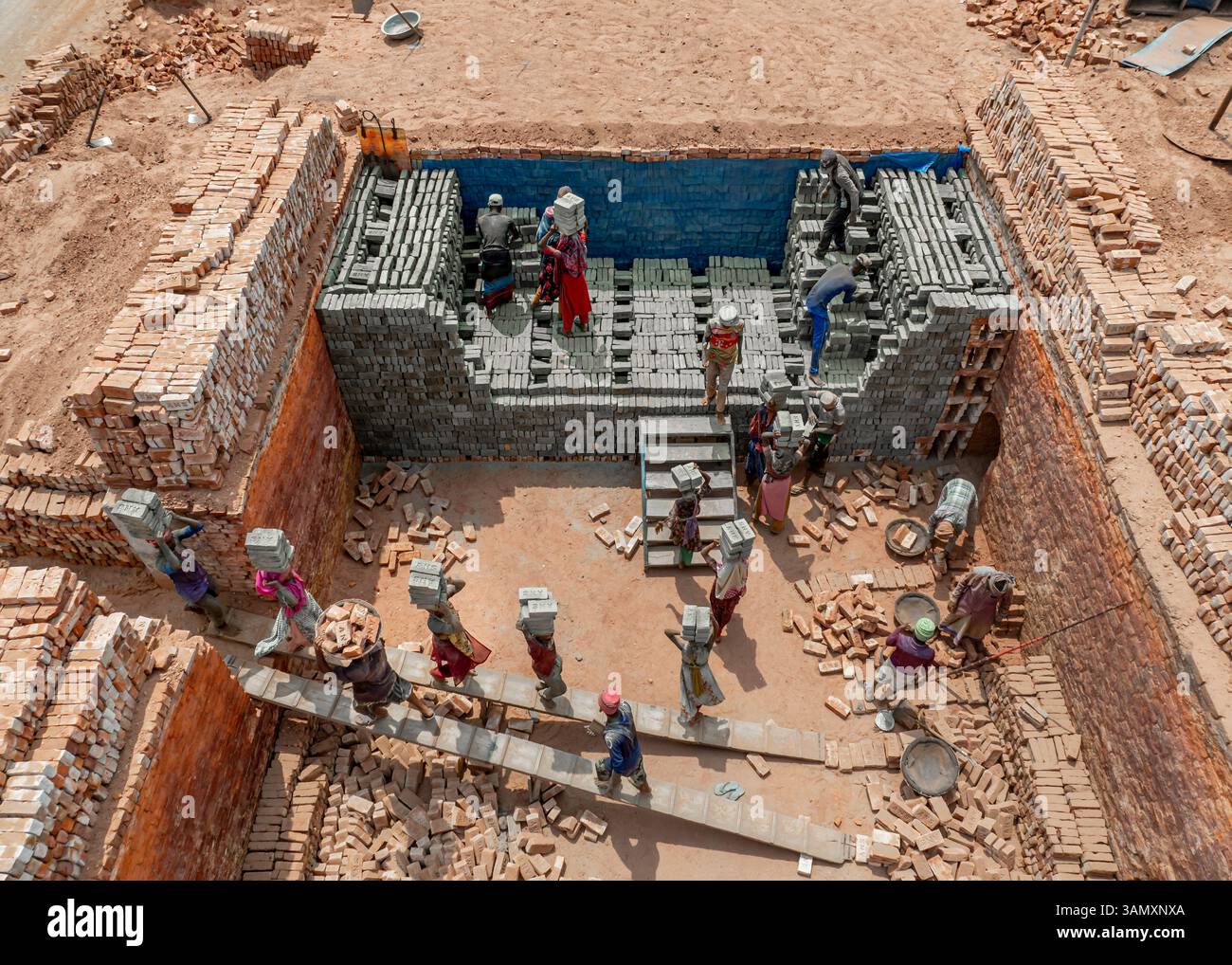 Aerial view of dusty brick making yard with manual laborers drying wet ...