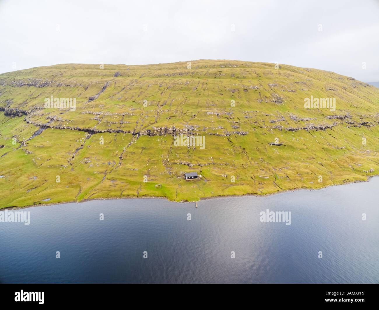 Aerial view of lonely house at the foot of mountain elevation, Faroe ...