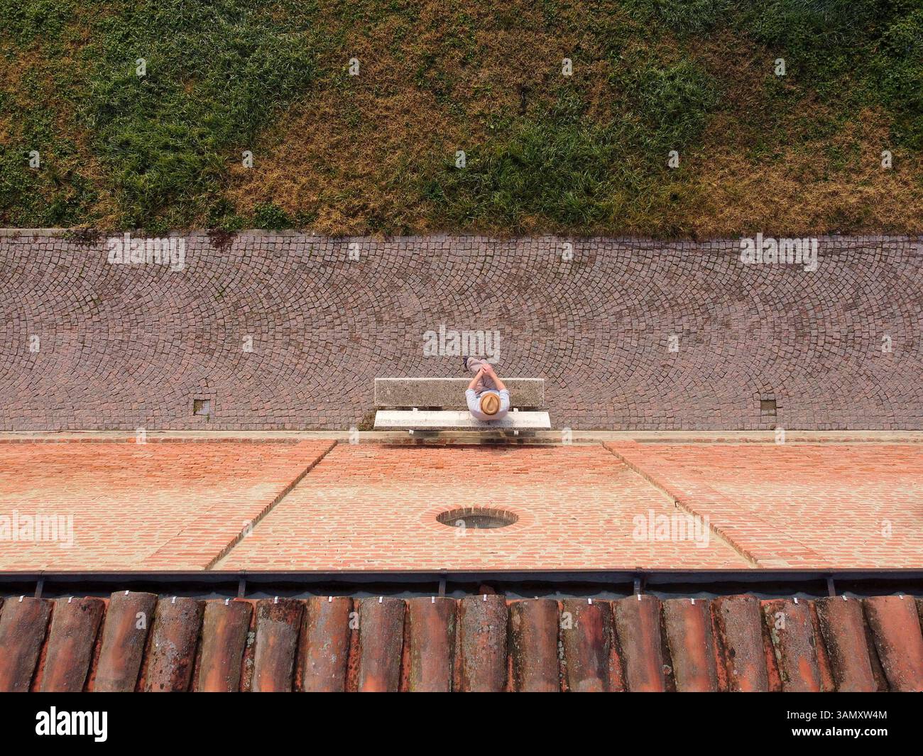 Aerial view of a person laying down in a ground sit on a bench ...