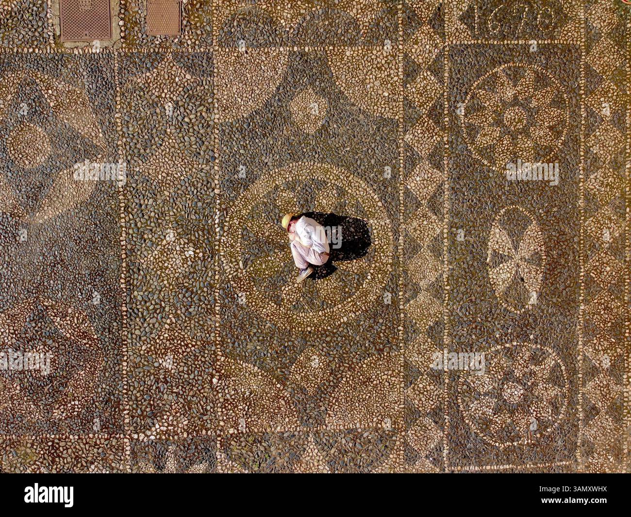 Aerial view of a person laying down on the ground with old mosaic ...