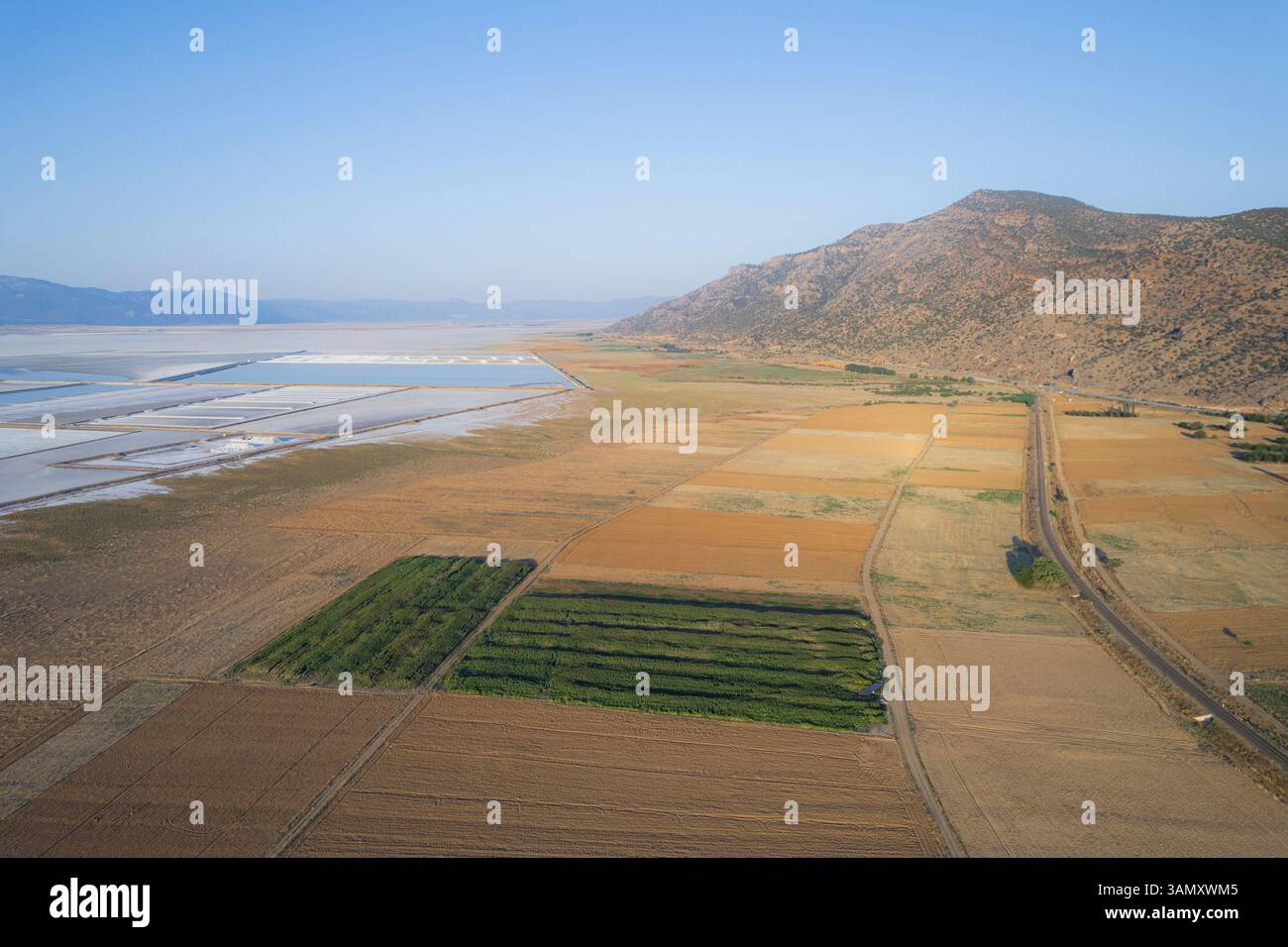 Aerial view of serene salt farm plots and fields with a mountain ...