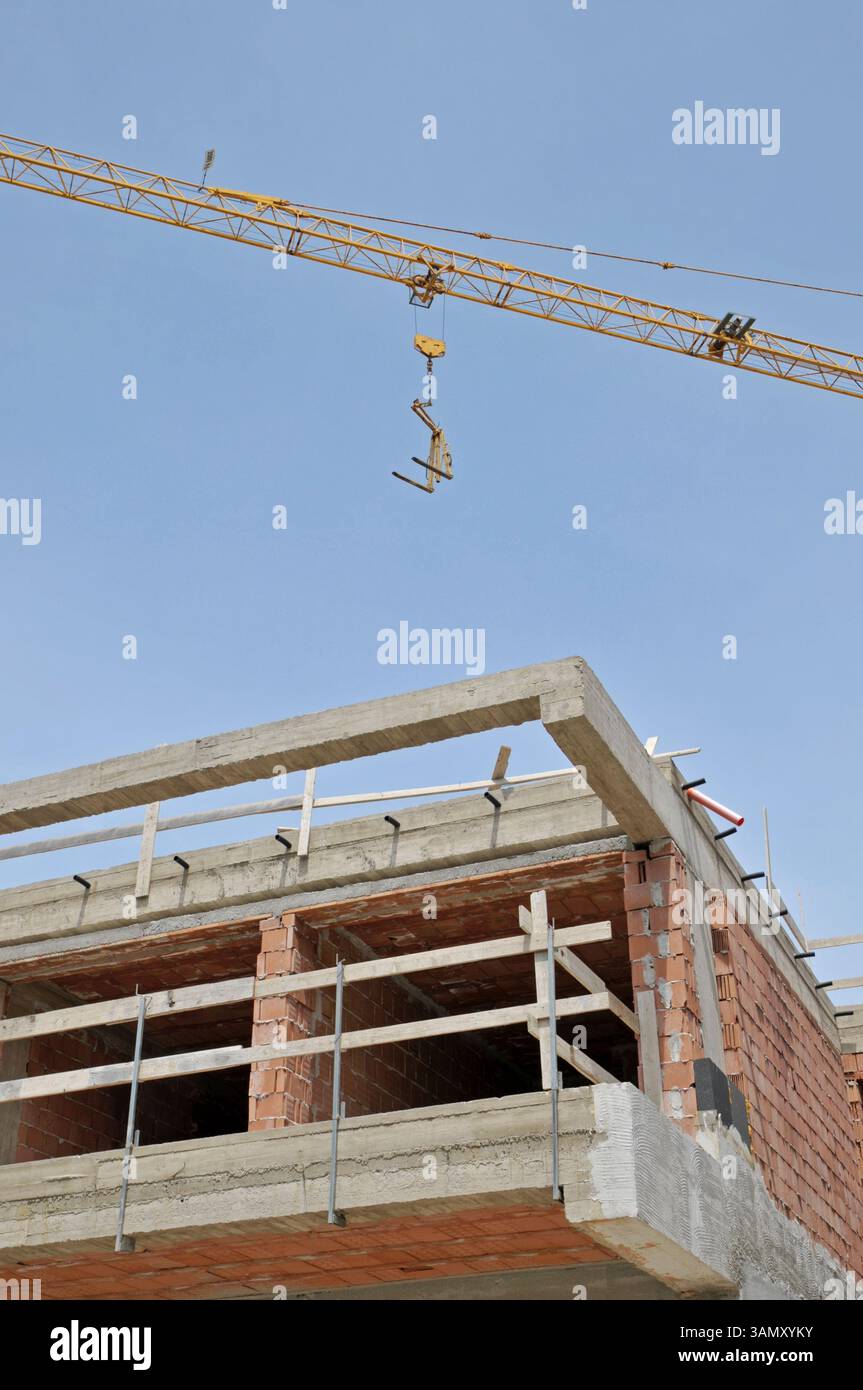 construction crane hook and unfinished building Stock Photo - Alamy