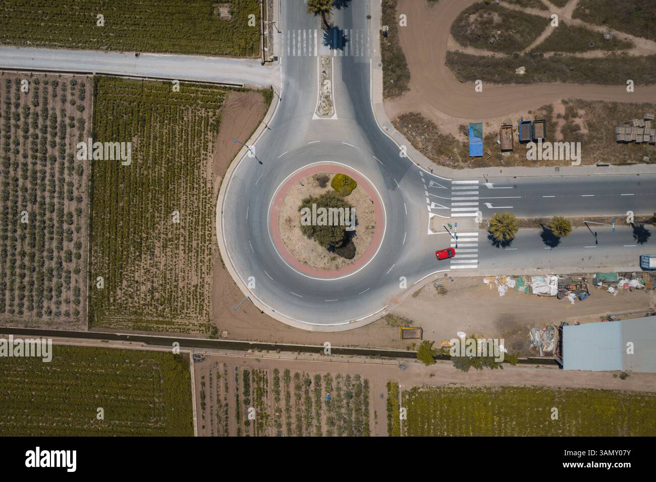 Aerial view of a roundabout with a red car driving on the side in ...