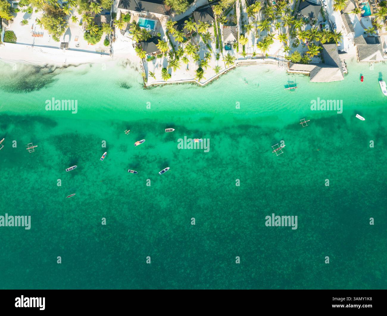 Aerial view of serene turquoise coastline with boats along a beautiful ...