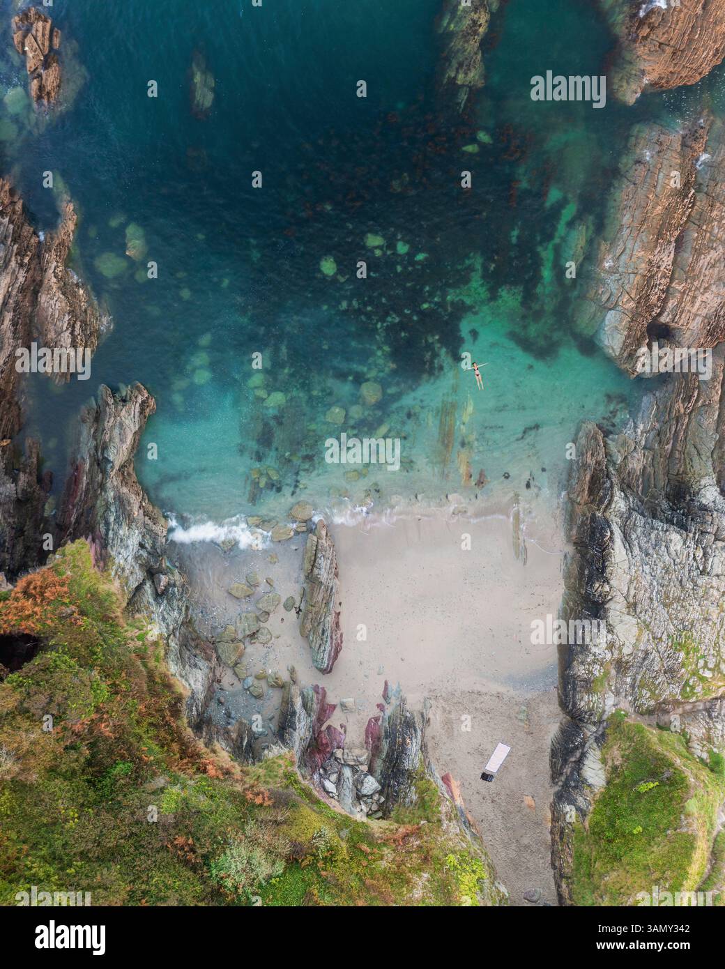 Aerial view of swimmer at secret cove, Talland Bay, Cornwall, United ...