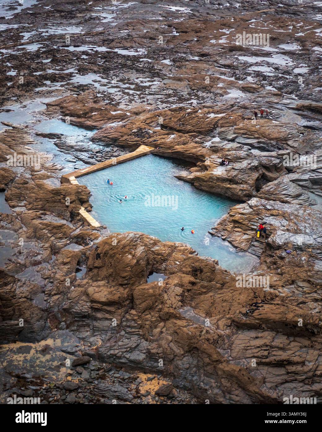 Aerial view of Trevone natural sea pool with people cold water swimming ...