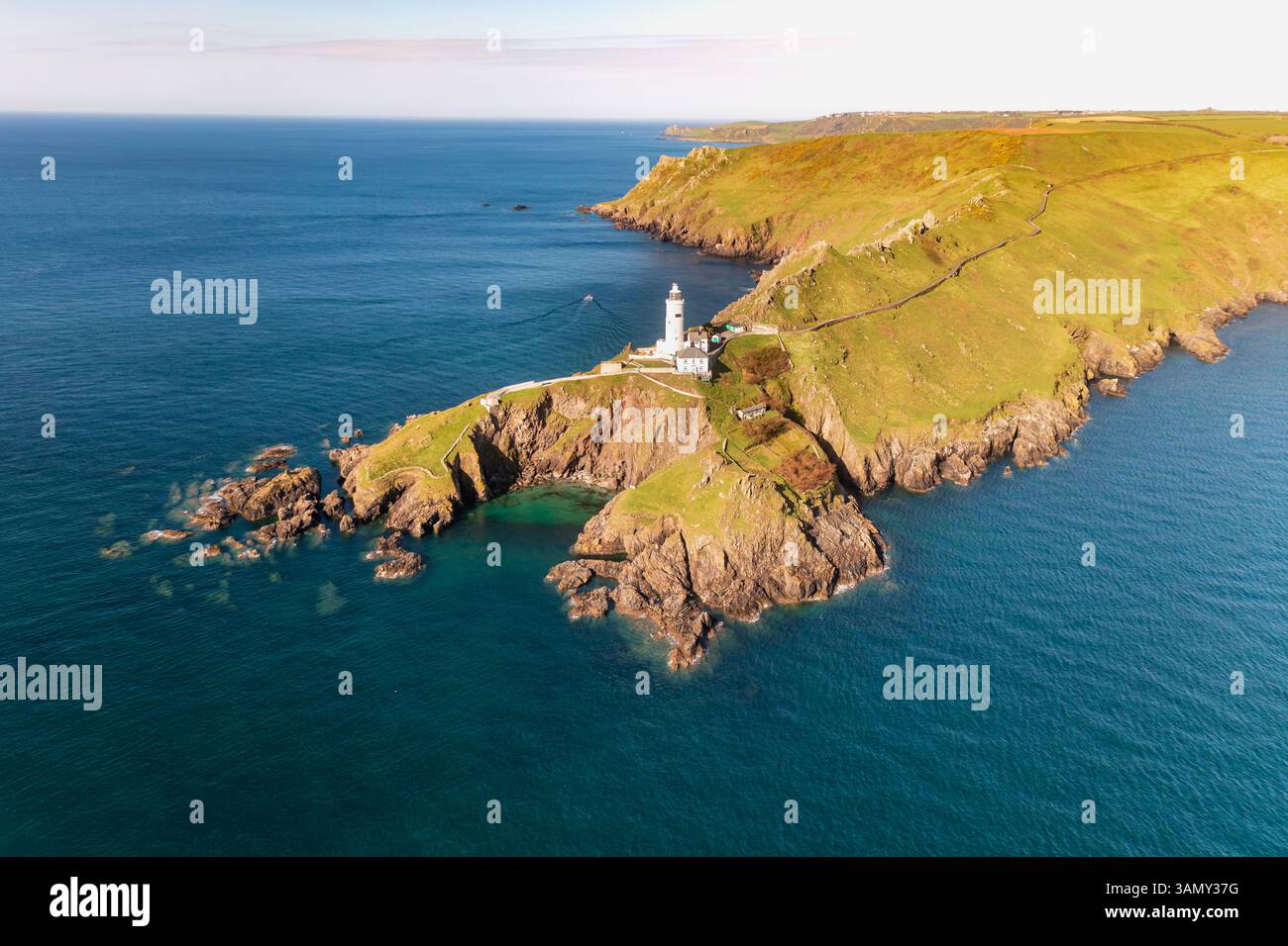 Aerial view of Start Point Lighthouse, cliffs, and ocean at headland ...