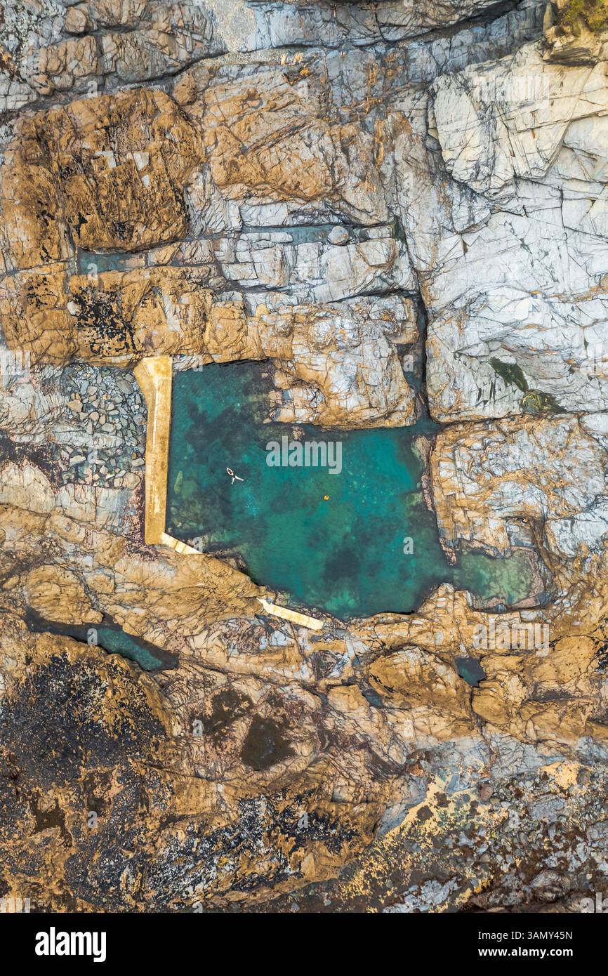 Aerial view of Trevone natural sea pool with people cold water swimming ...