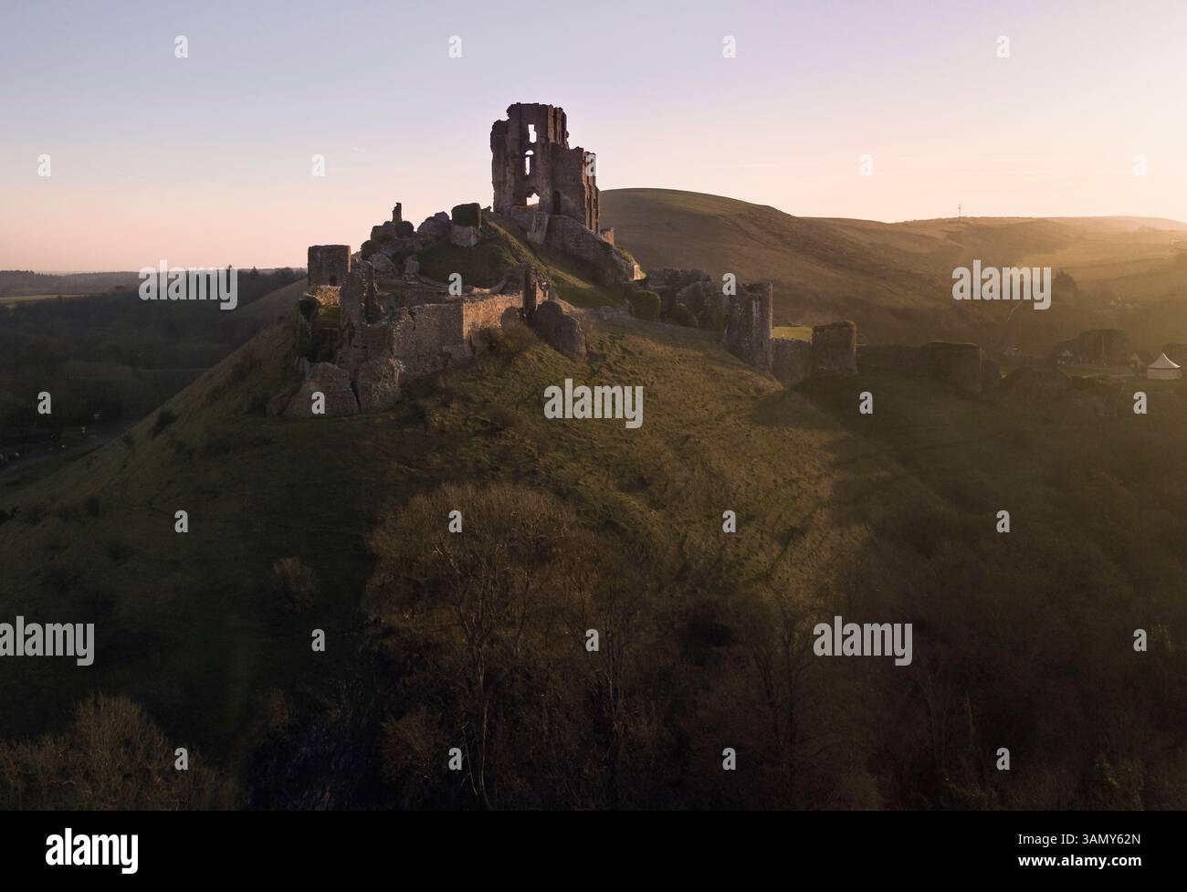 Aerial view of Corfe Castle during a dramatic sunrise, Dorset, United ...