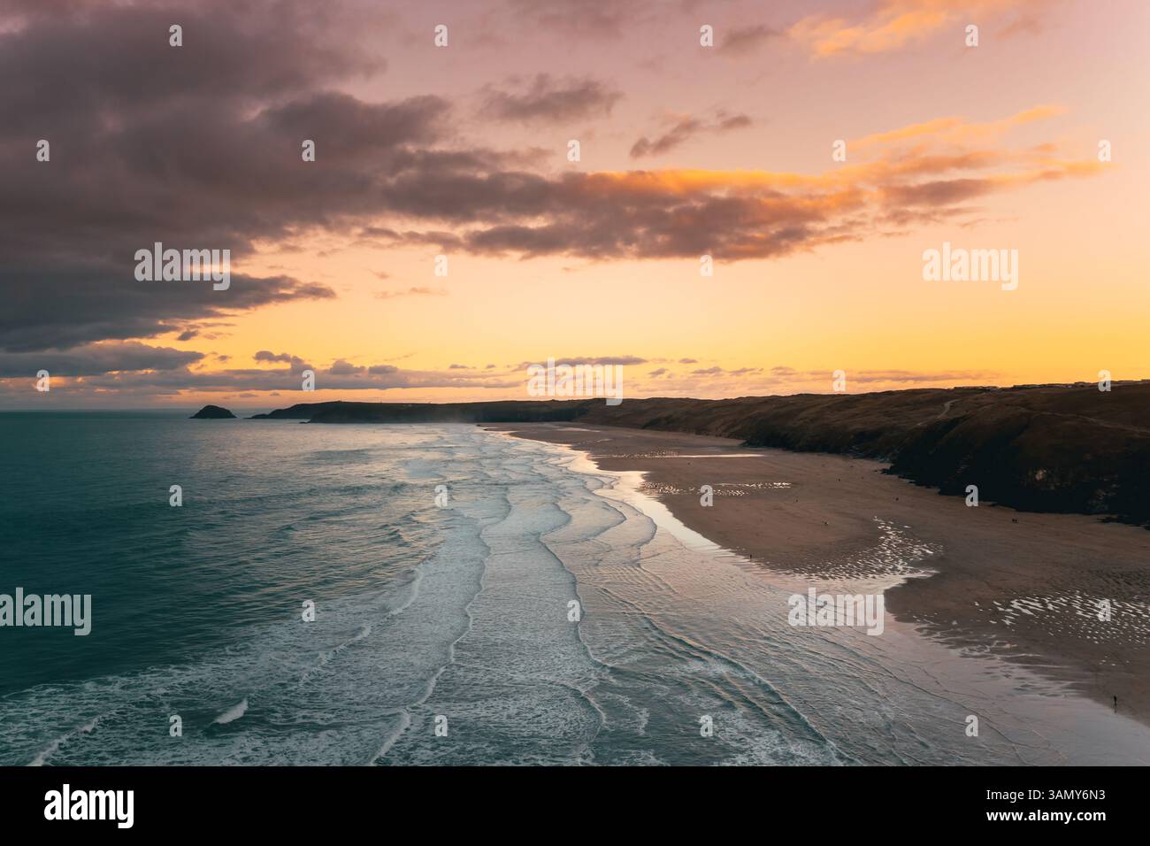 Aerial view of surfers at sunset, Perranporth beach, Ligger bay ...