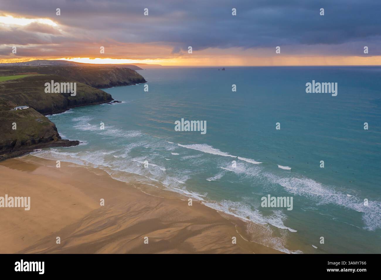 Aerial view of surfers at sunset, Perranporth beach, Ligger bay ...