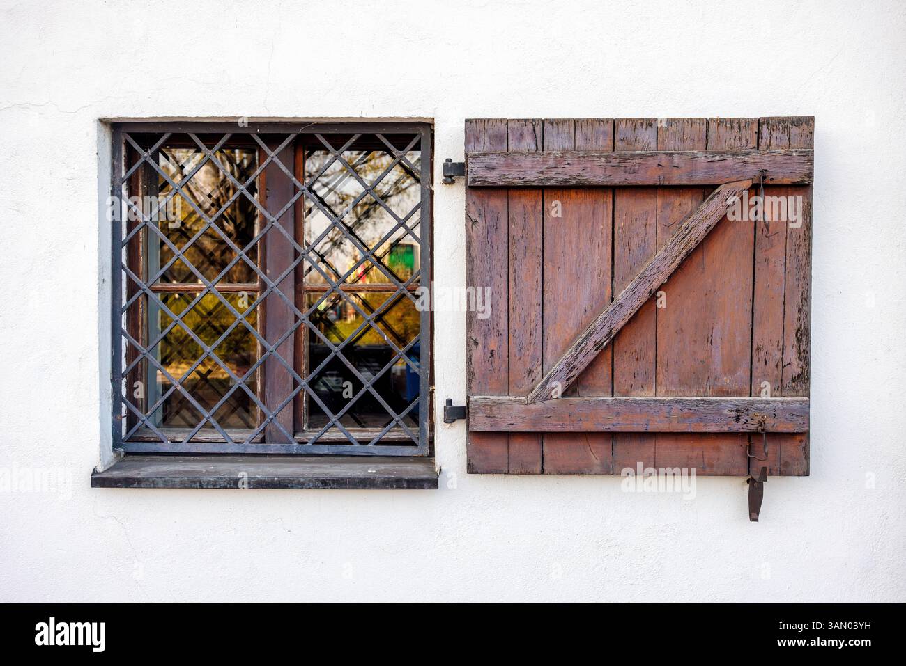 European farm building with small barred window with tilting wooden ...