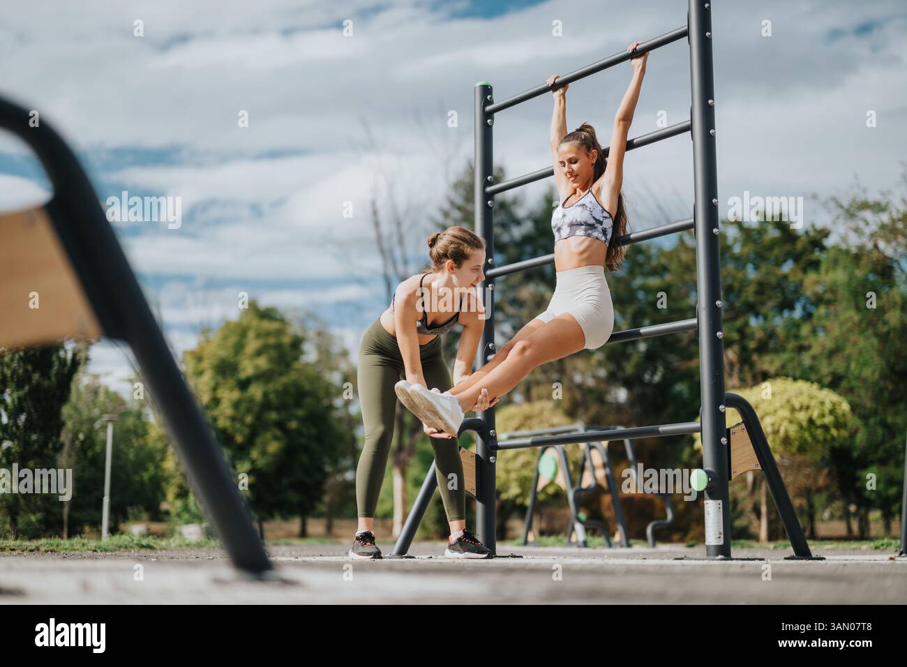 Two Women Exercising in an Outdoor Park Using Monkey Bars for Strength ...