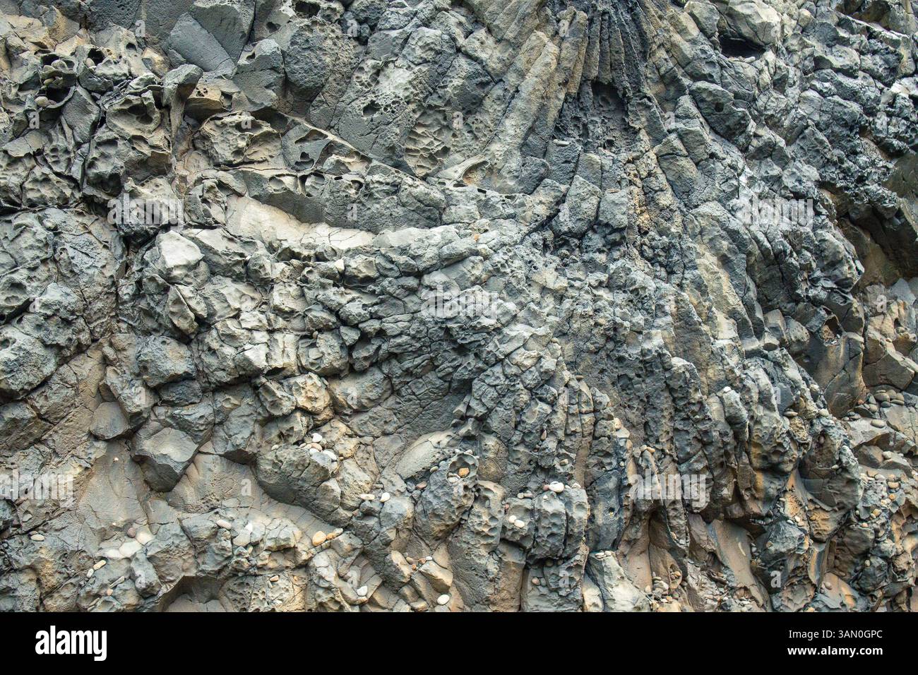 Intricate patterns and textures are visible in a rocky coastal ...