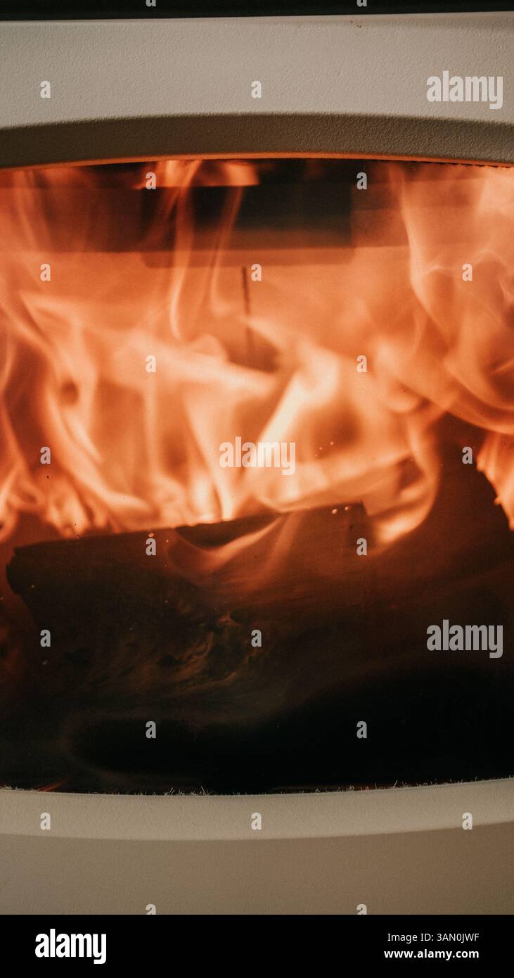 A fire is burning in a fireplace, with the flames reaching up to the ...