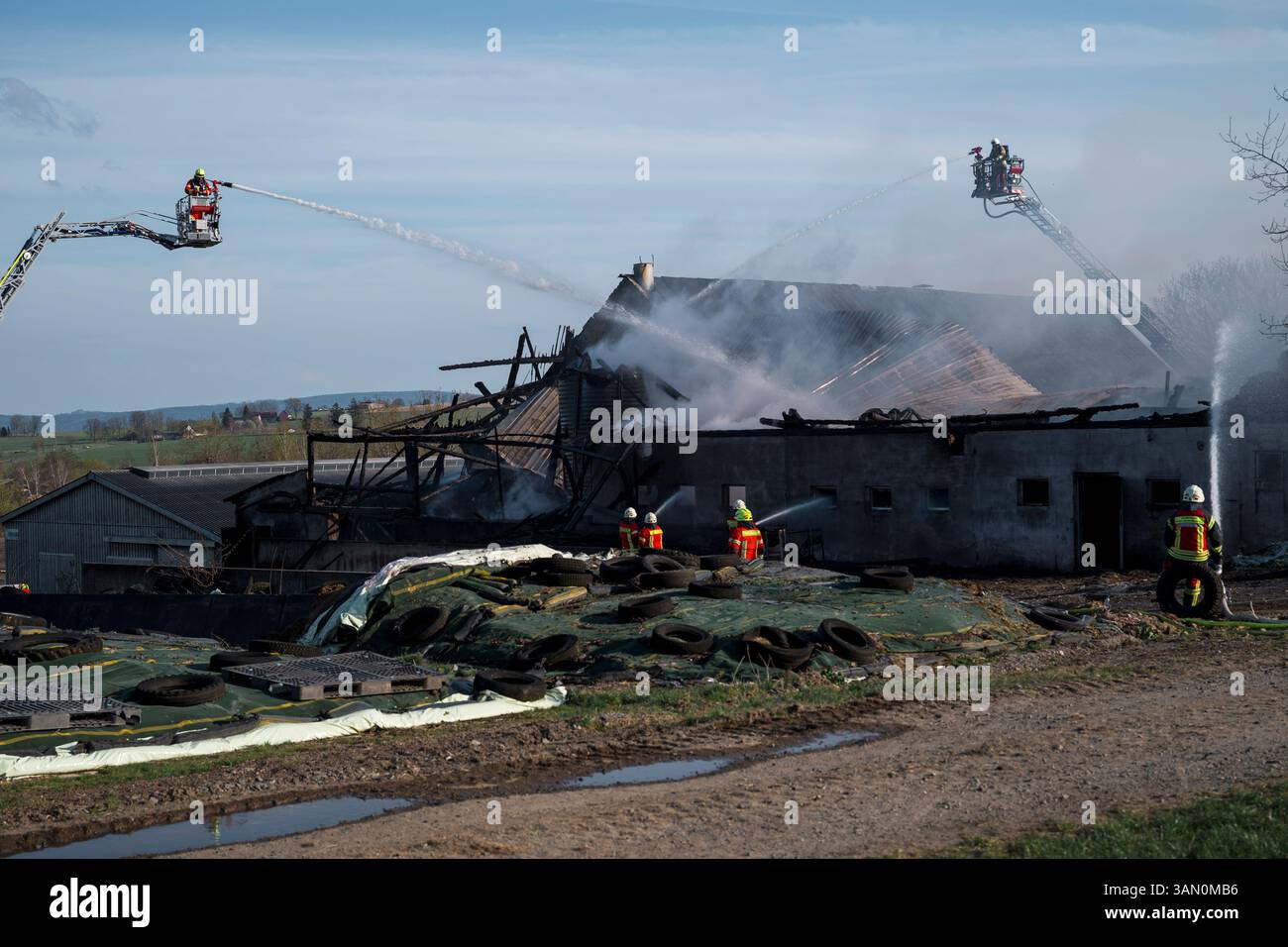 Helmbrechts, Germany. 14th Apr, 2025. Firefighters extinguish the fire ...