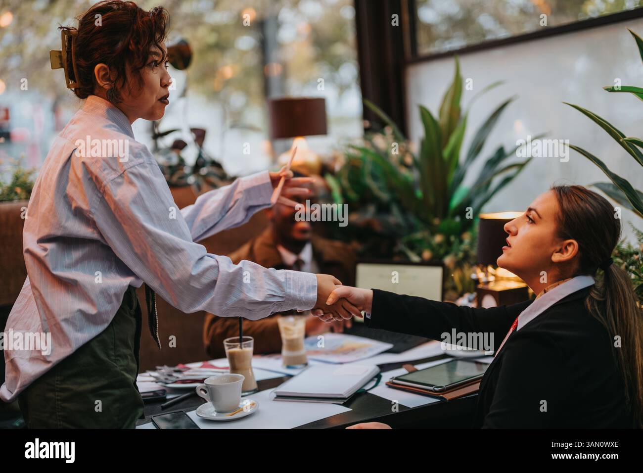 Business colleagues collaborating and sharing ideas in a coffee shop ...