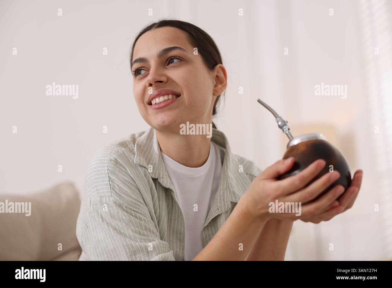 Woman drinking traditional yerba mate tea indoors Stock Photo - Alamy