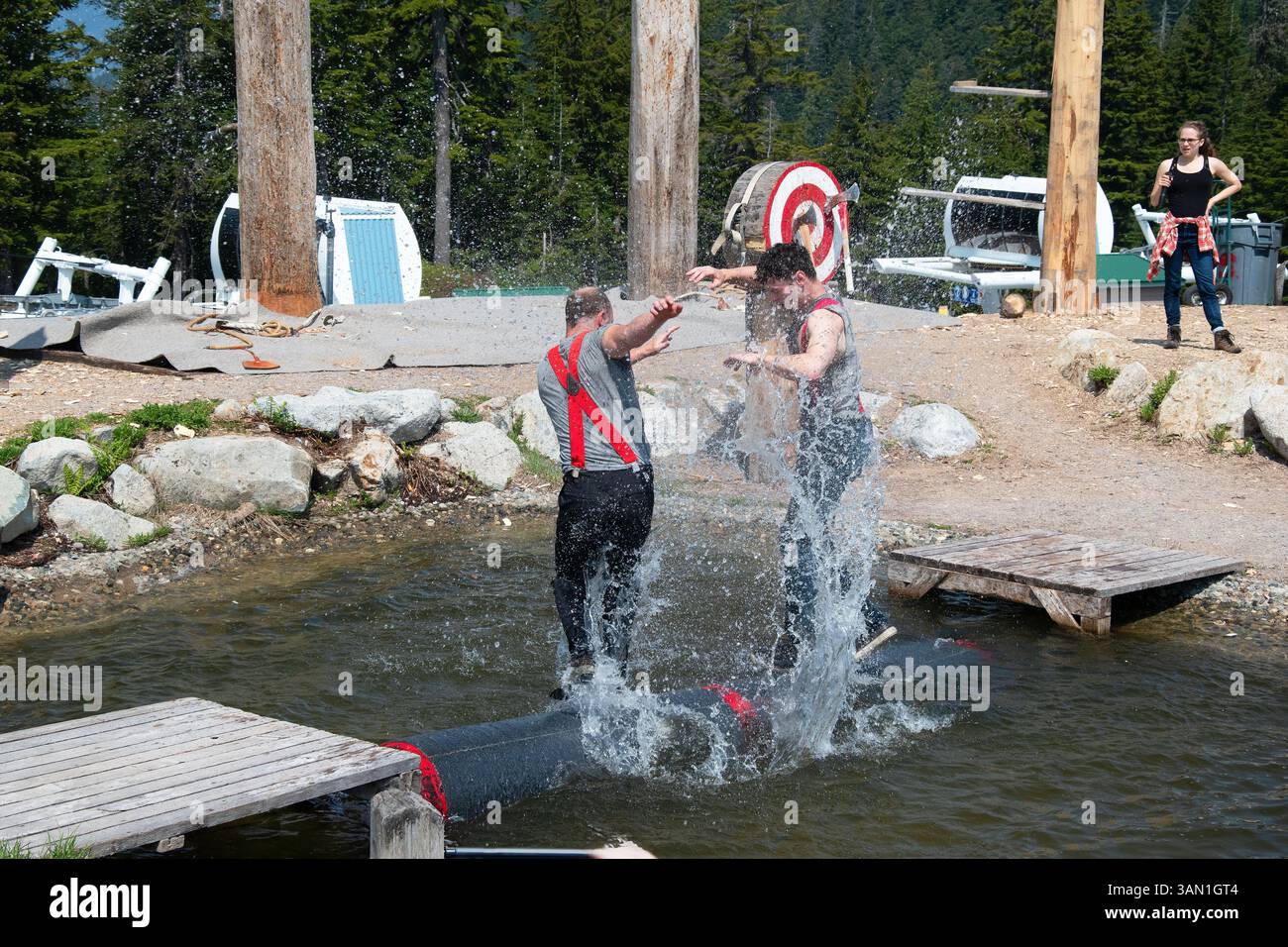 Two lumberjacks compete in a log rolling competition, trying to knock ...