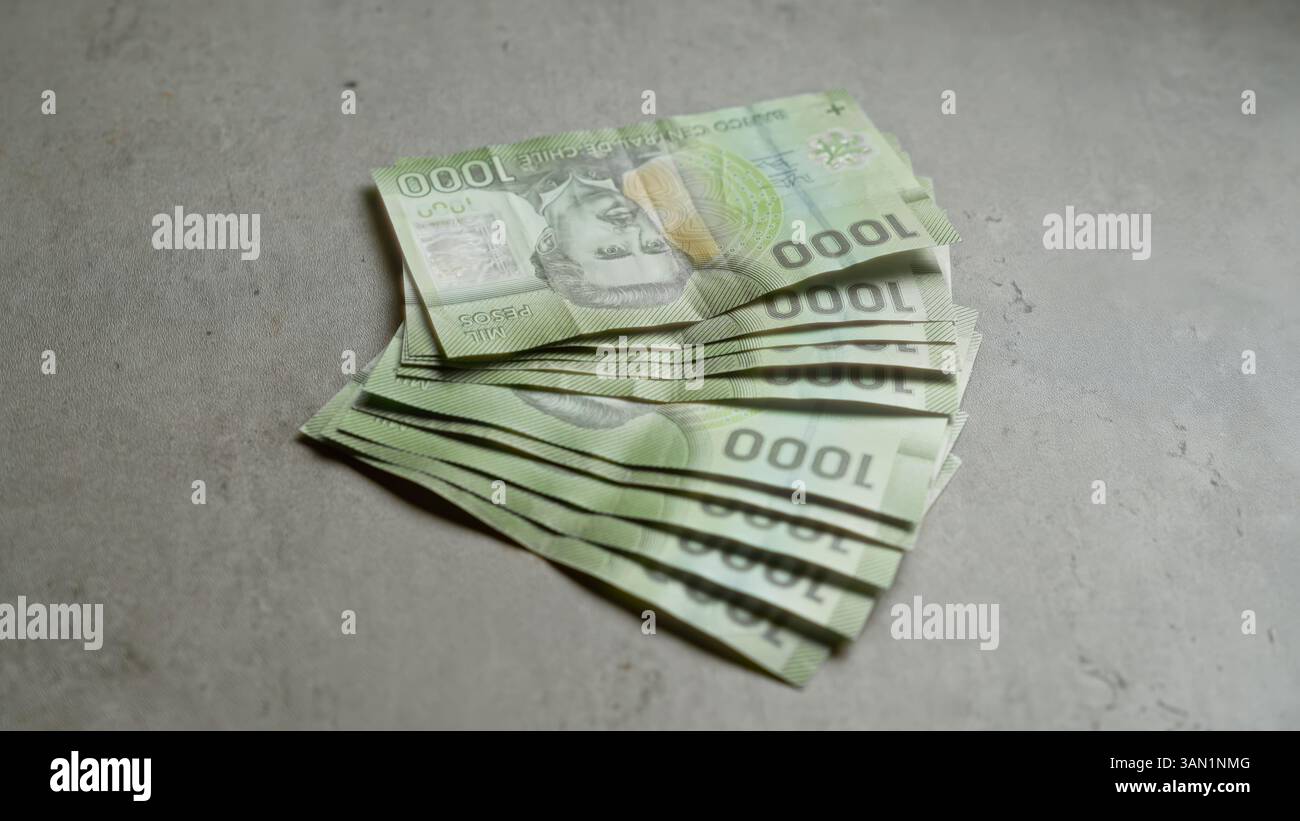 Chilean banknotes in denominations of 1000 pesos spread out on a ...