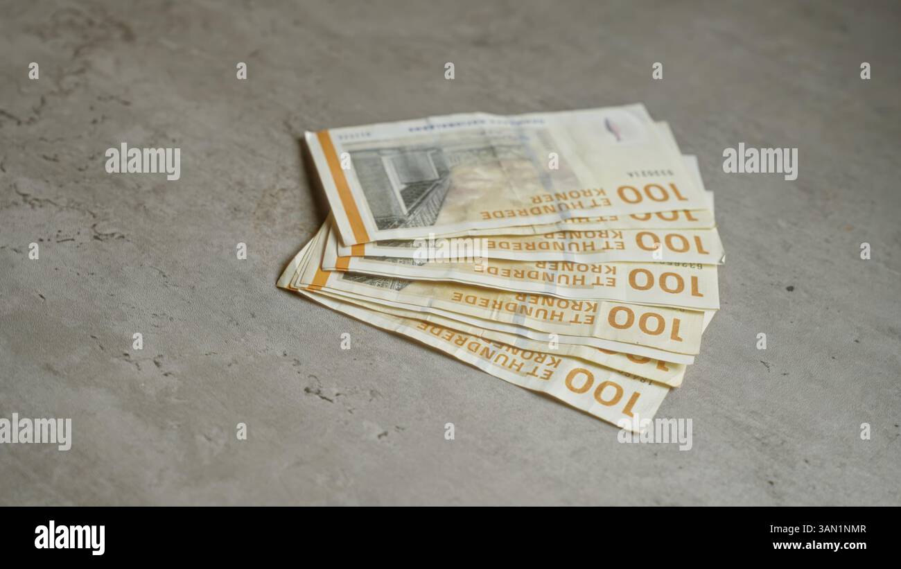 Danish banknotes scattered on a concrete surface, showcasing the 100 ...