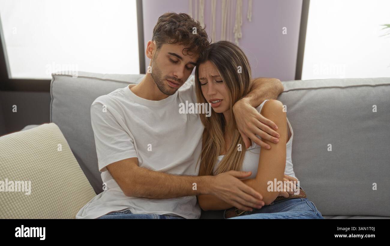 Couple embracing on sofa in cozy living room where man comforts woman ...