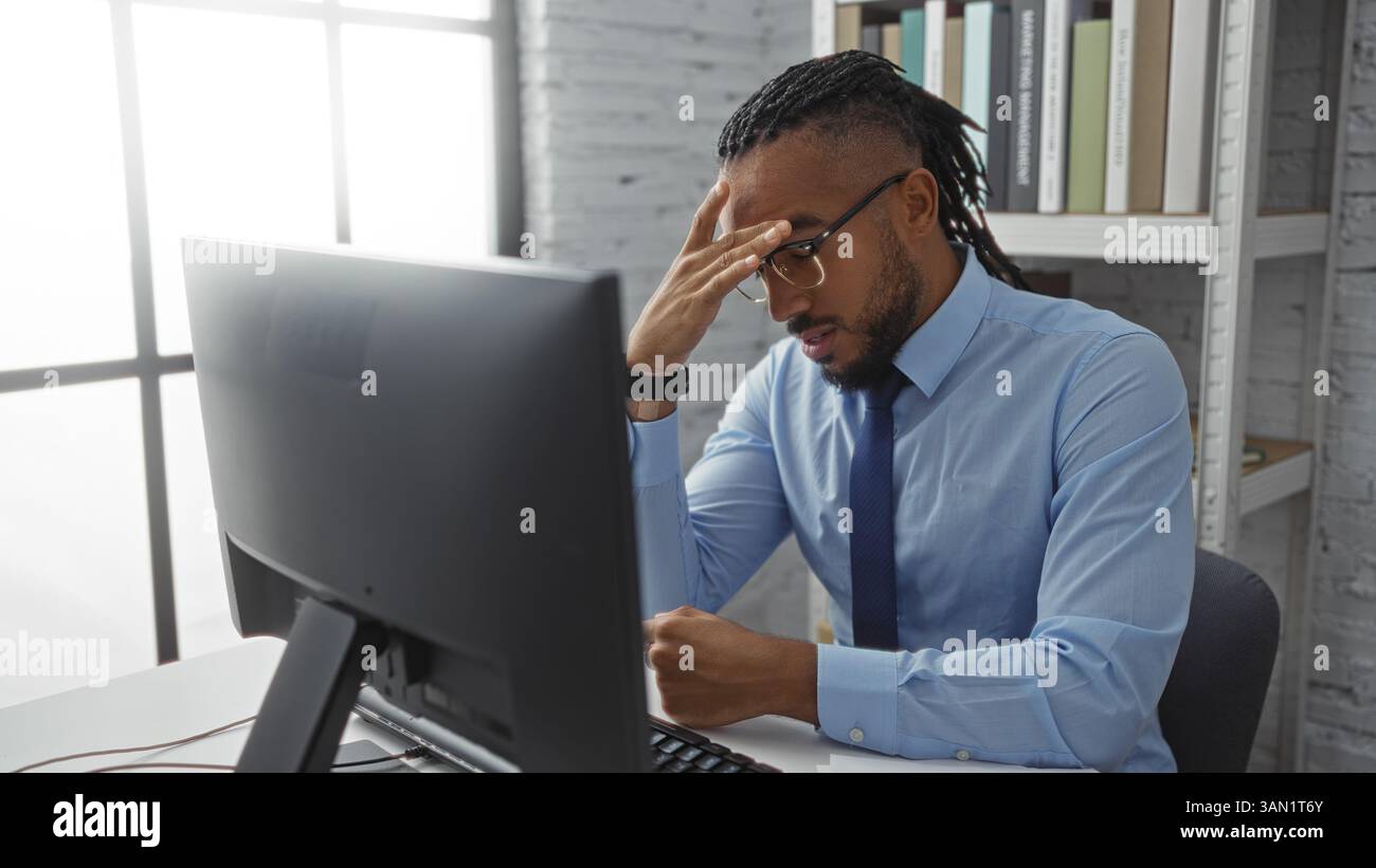 Young man with braids working in an office, wearing glasses and a blue ...
