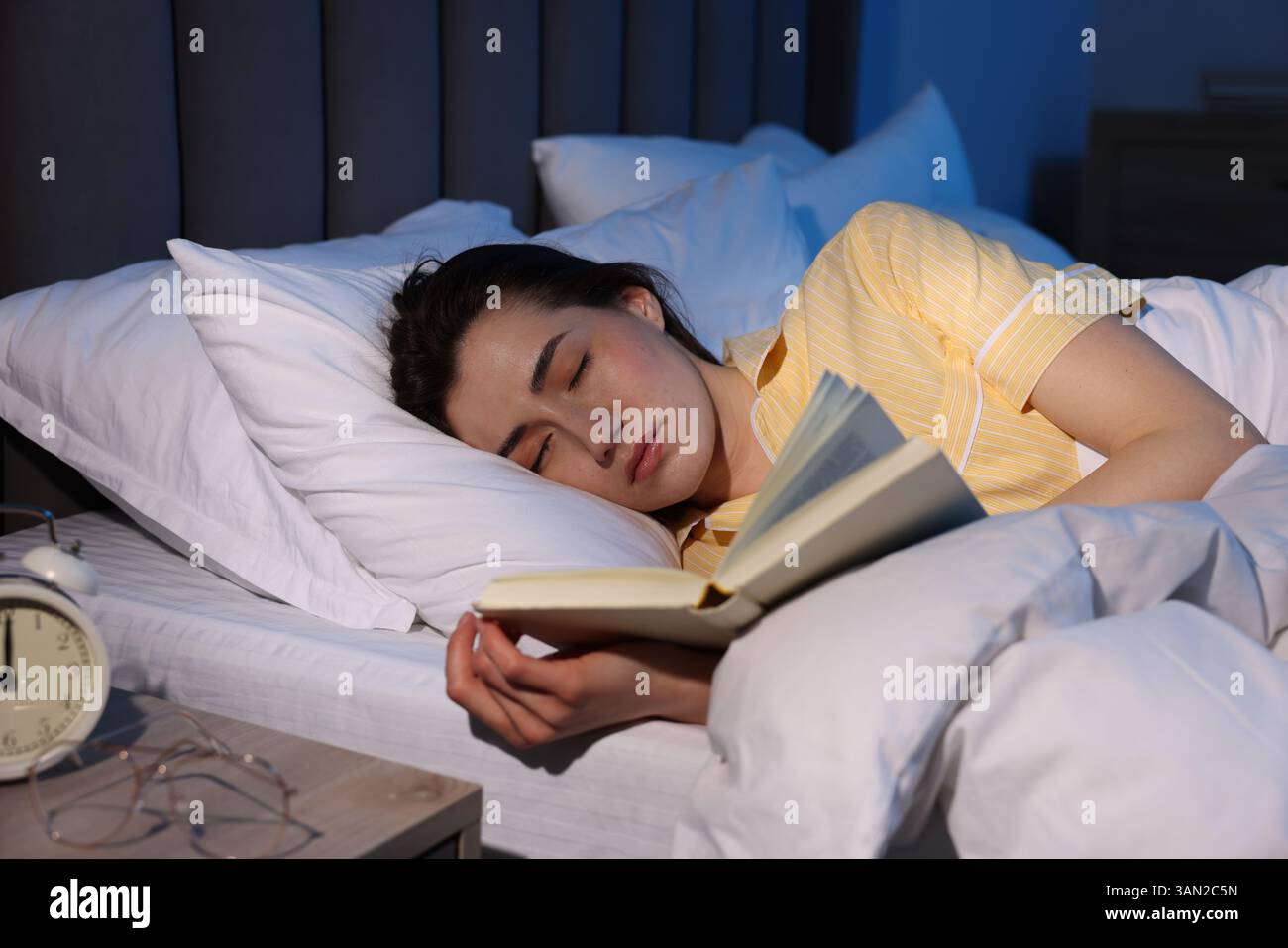 Young woman sleeping with book in bed at home Stock Photo - Alamy