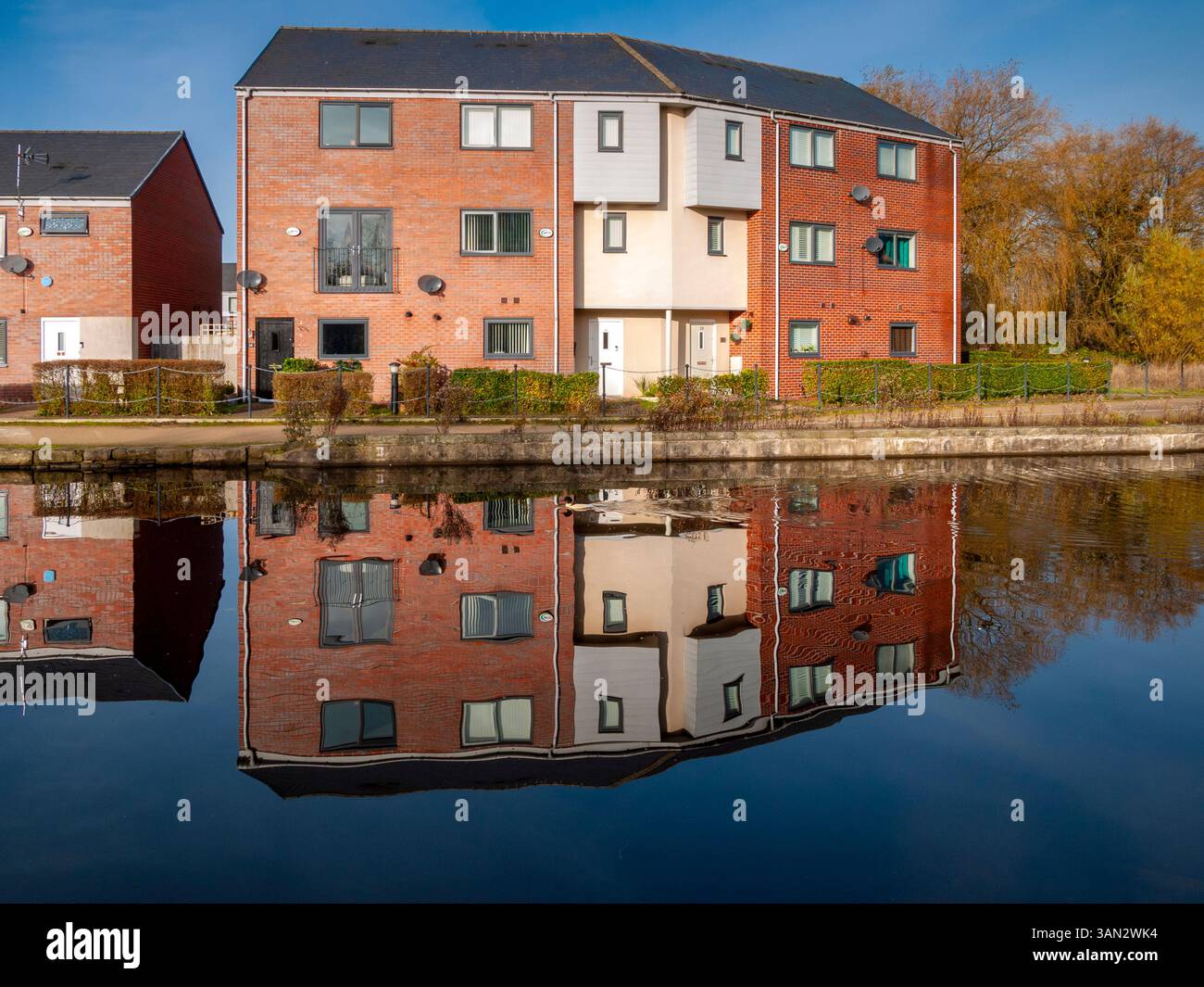 Canalside homes reflected in the Ashton Canal, Droylsden Marina, Tameside, Manchester, England ...