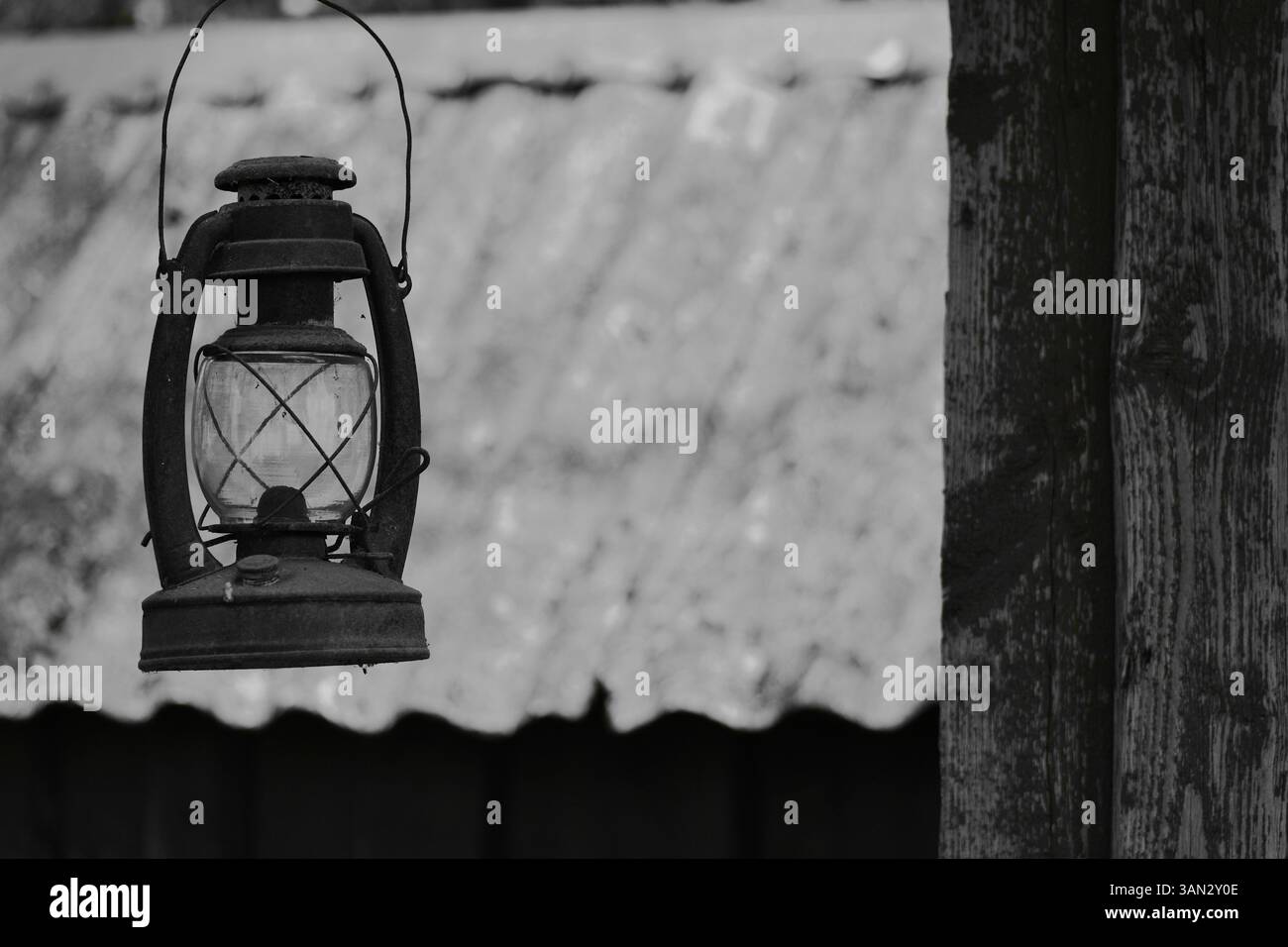 Old rusty kerosene lantern hanging outdoors in slate-covered roof ...