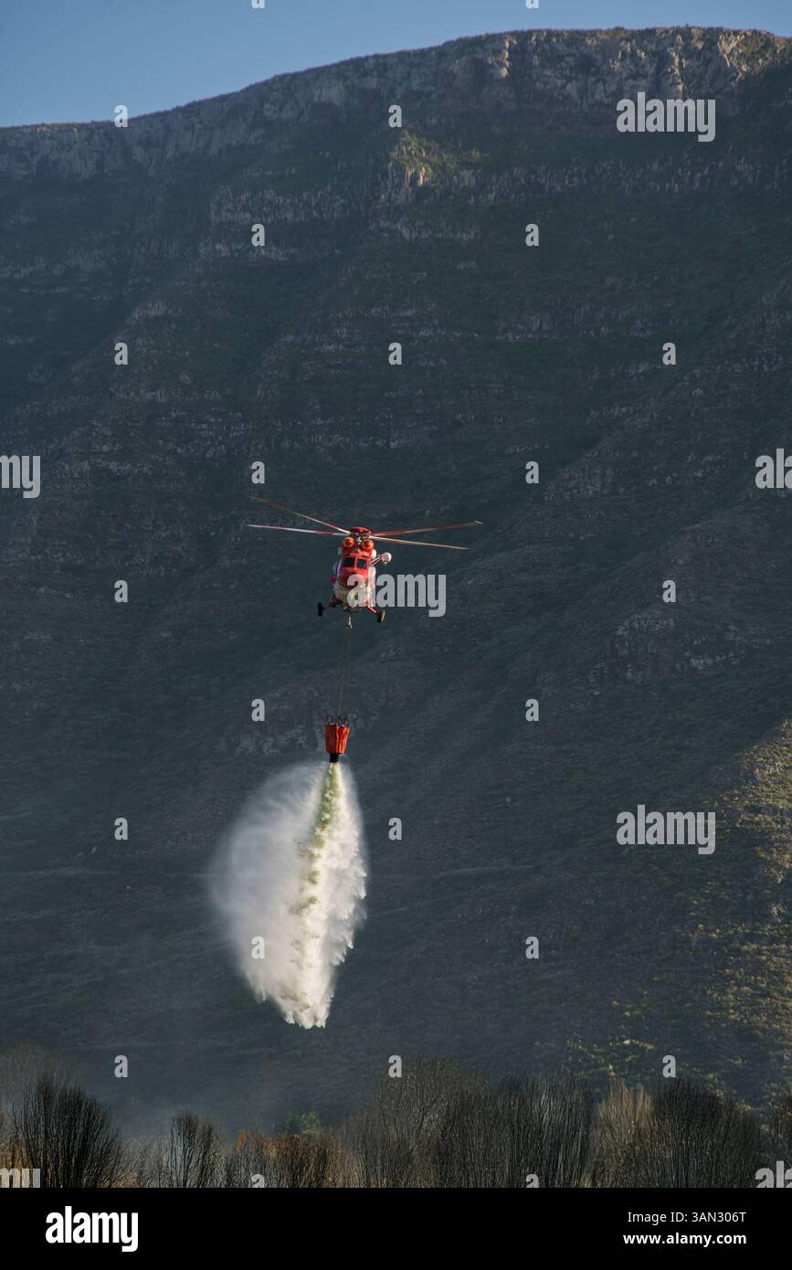 Fire fighting helicopter releasing water from bucket Stock Photo - Alamy