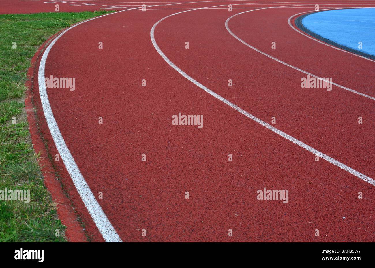 Red running track curve with blue sports field in right side and green ...