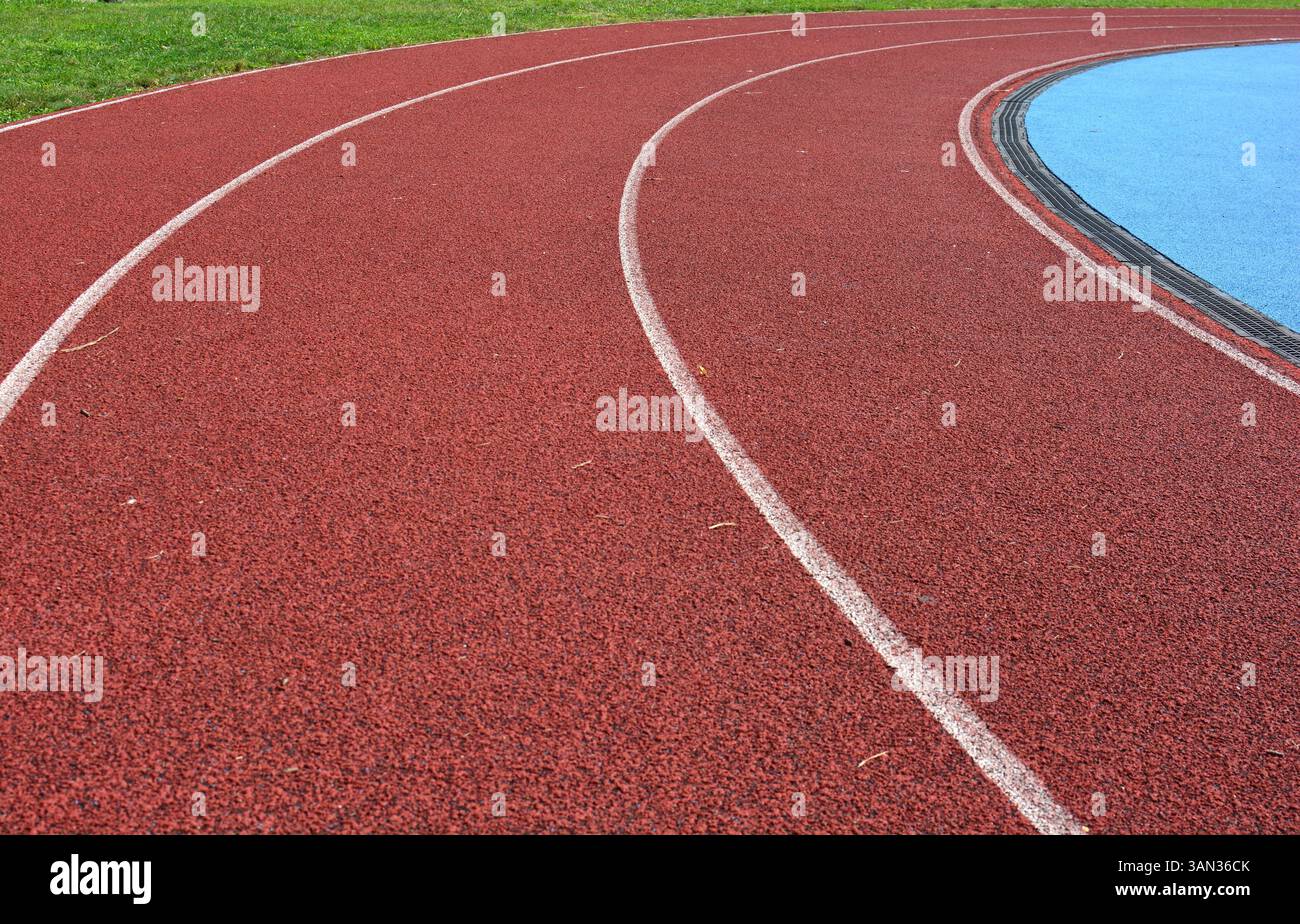 Red running track curve with blue sports field in right side and green ...