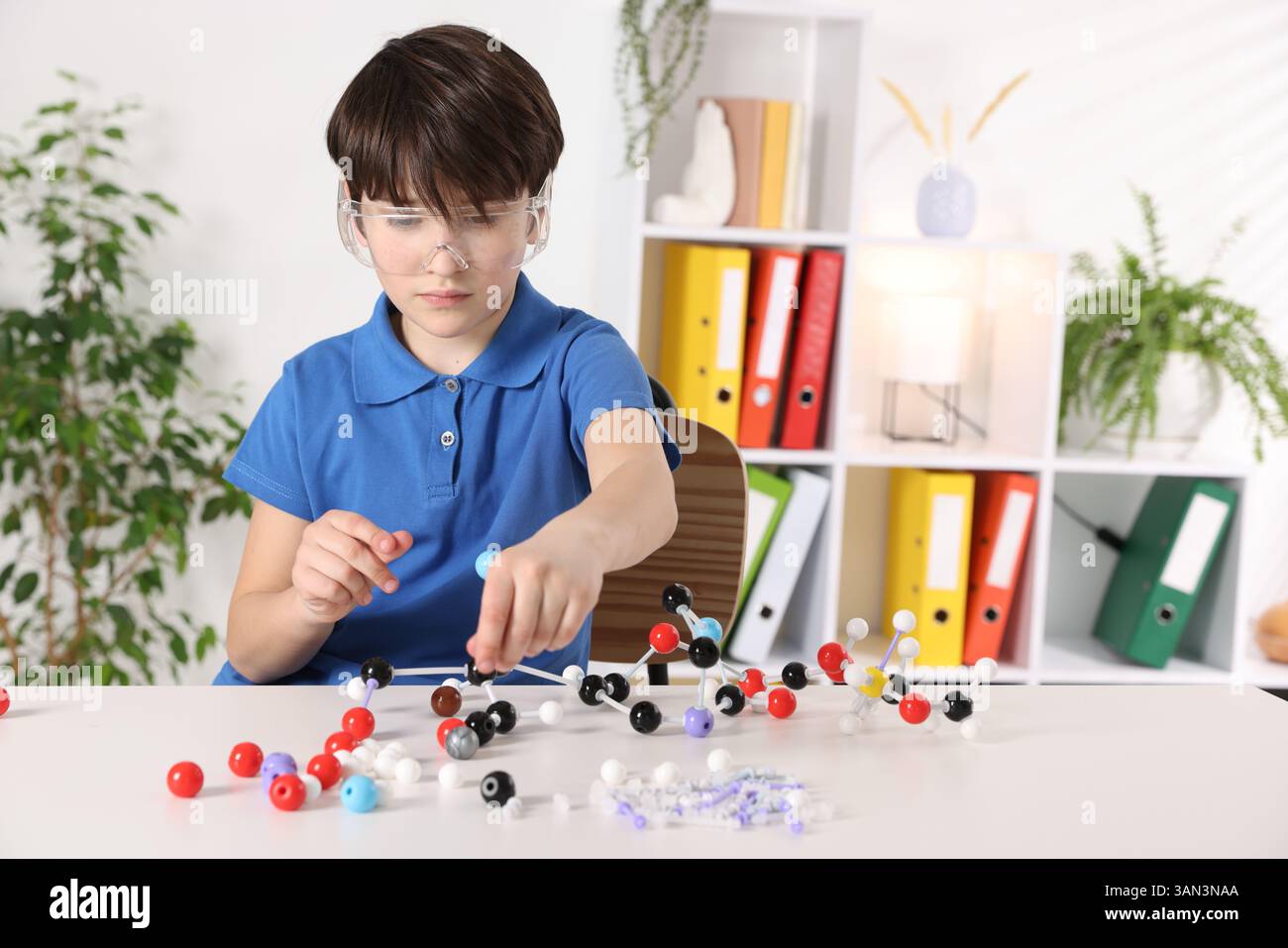 Boy making DNA structure model at desk indoors. Space for text Stock ...