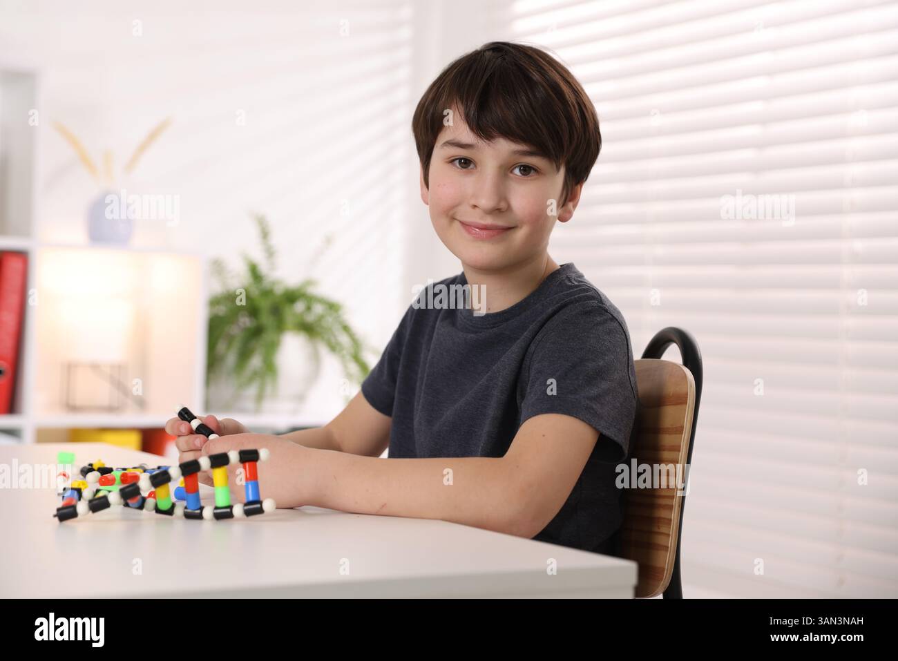 Boy making DNA structure model at desk indoors Stock Photo - Alamy