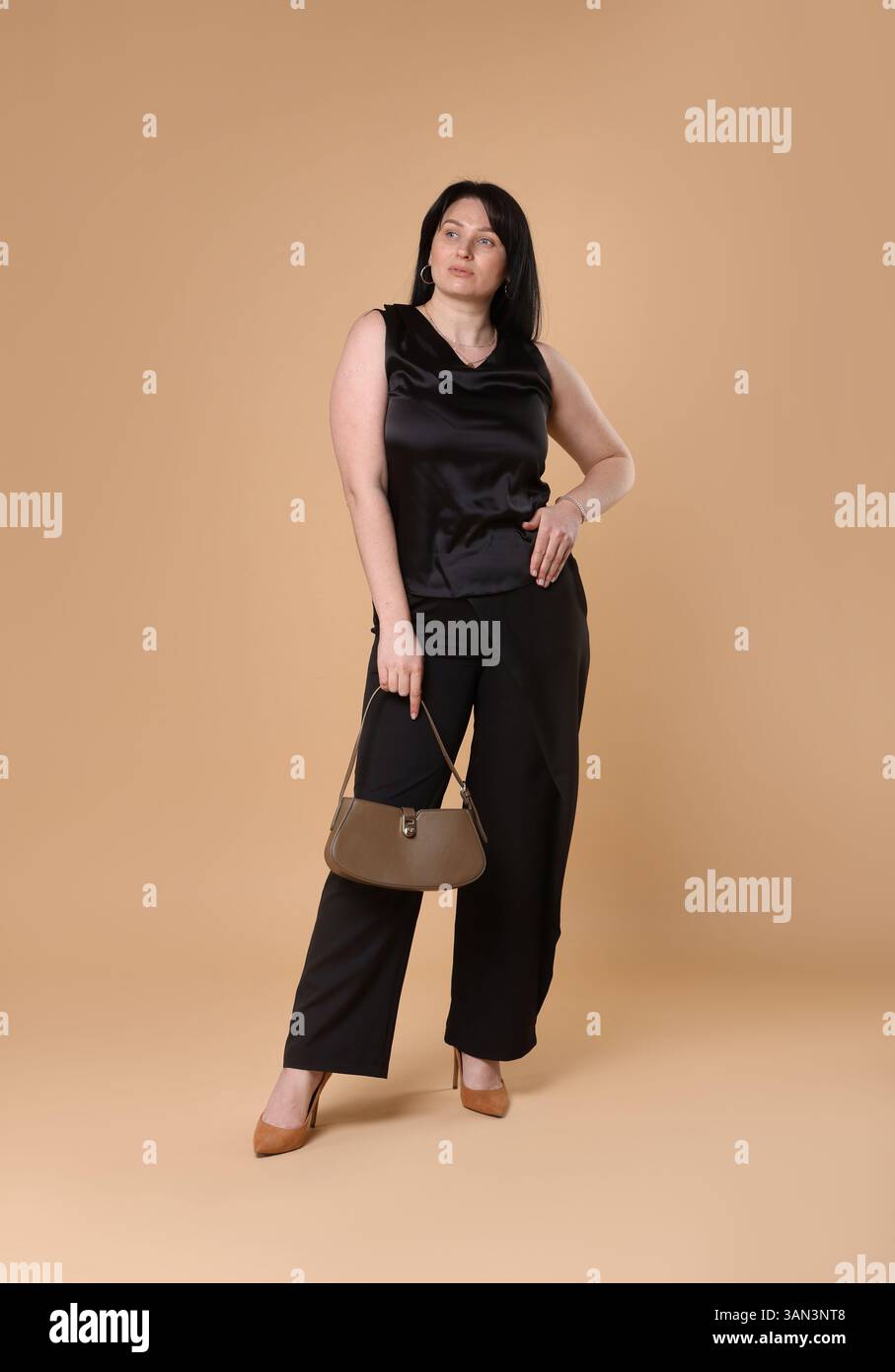 Elegant plus size model with bag on beige background. Overweight Stock ...