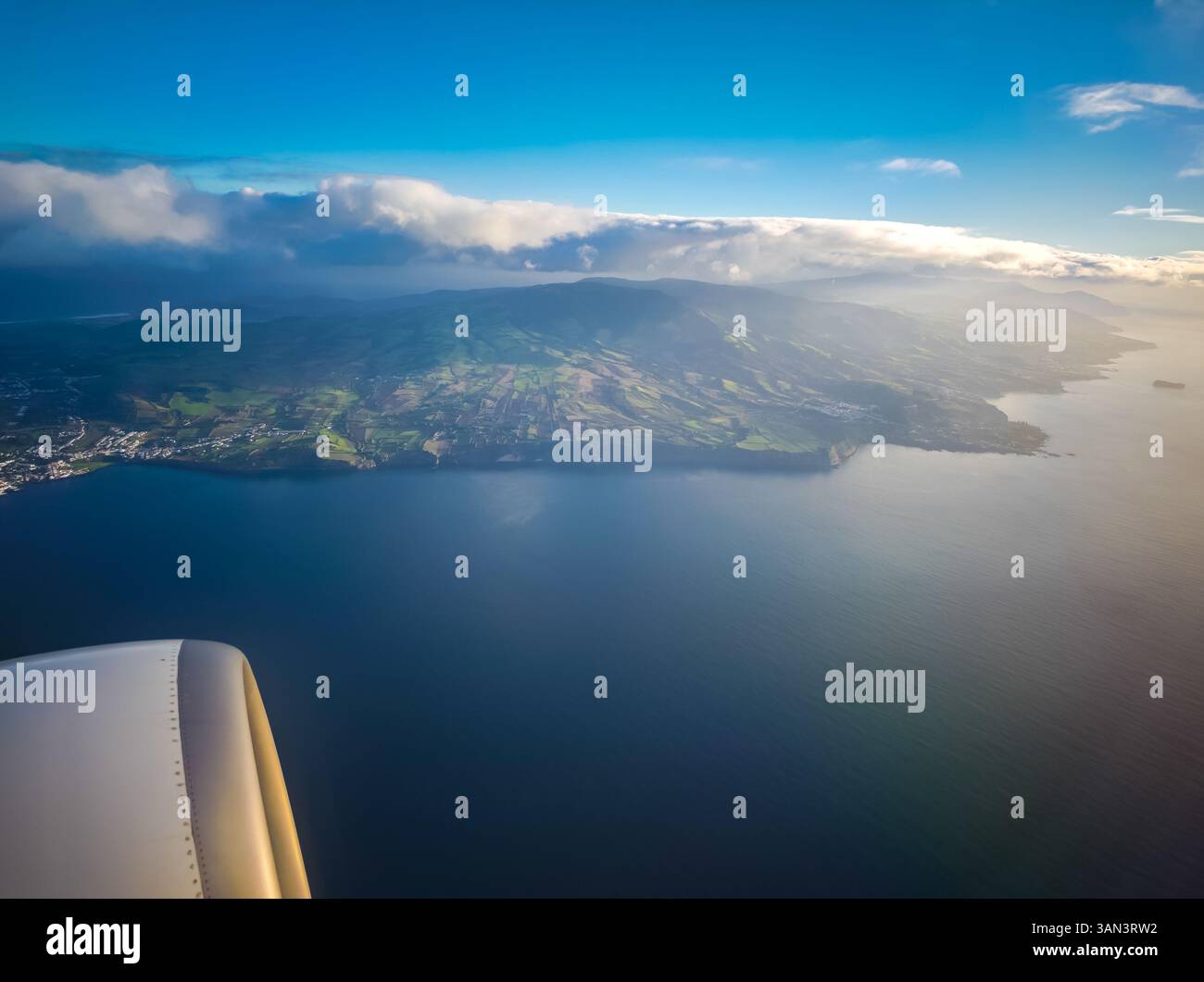 View of a tropical island in the middle of ocean from a plane window ...