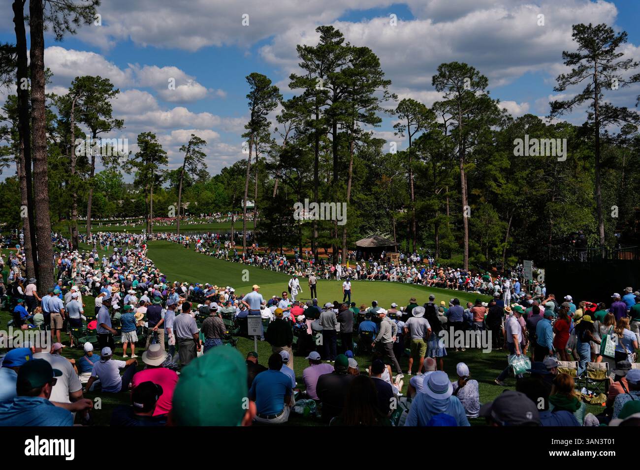Patrons watch on the seventh hole during the par-3 contest at the ...