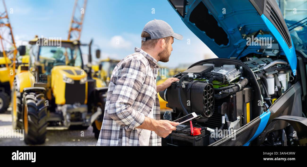 Man using digital tablet to inspect tractor engine with modern modern ...