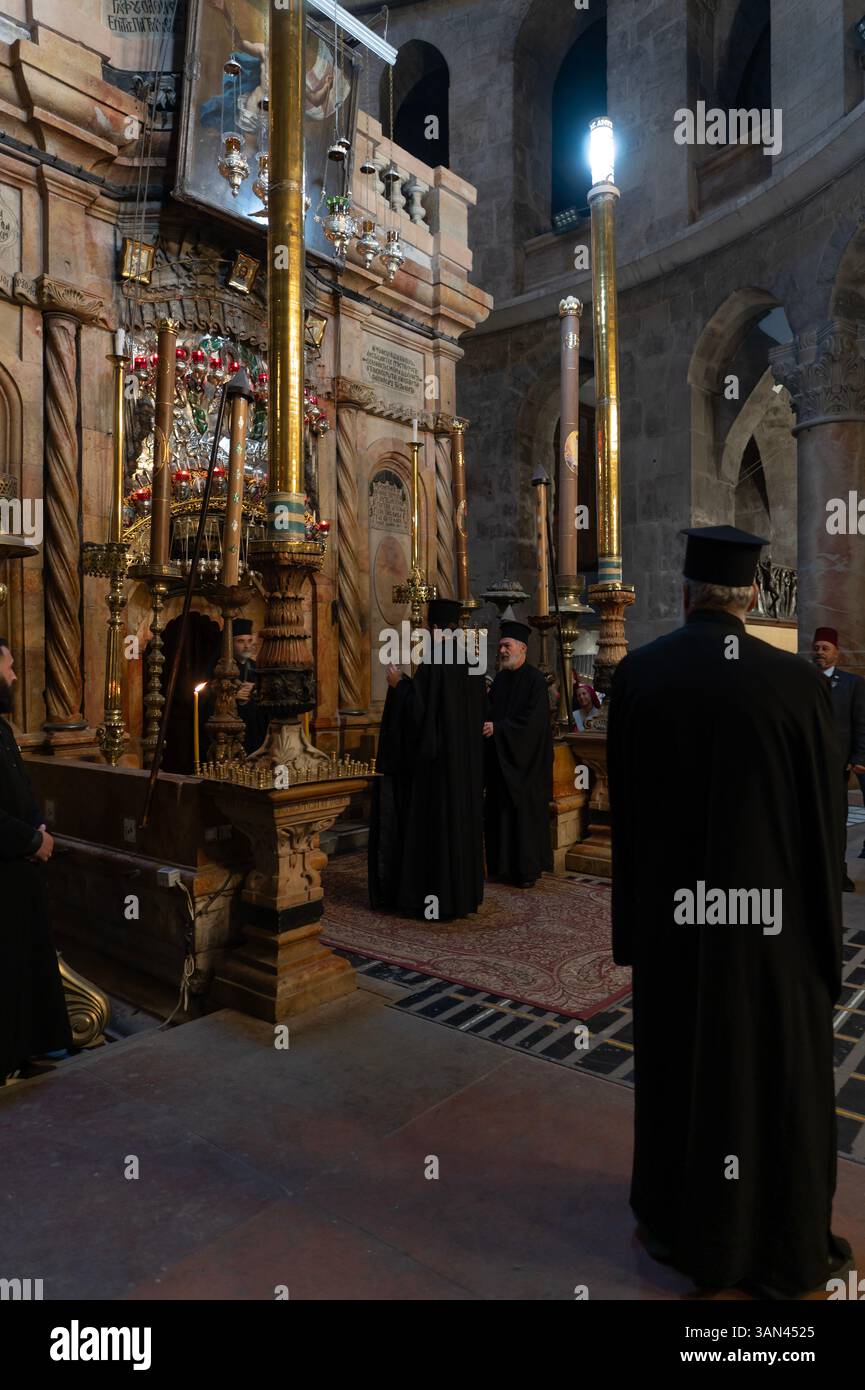 Greek Orthodox clergymen stand at the entrance to the Edicule or ...