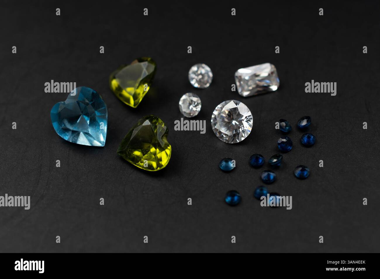 Closeup of colorful crystal hearts with faceted surfaces, vibrant gemstones displayed on black ...