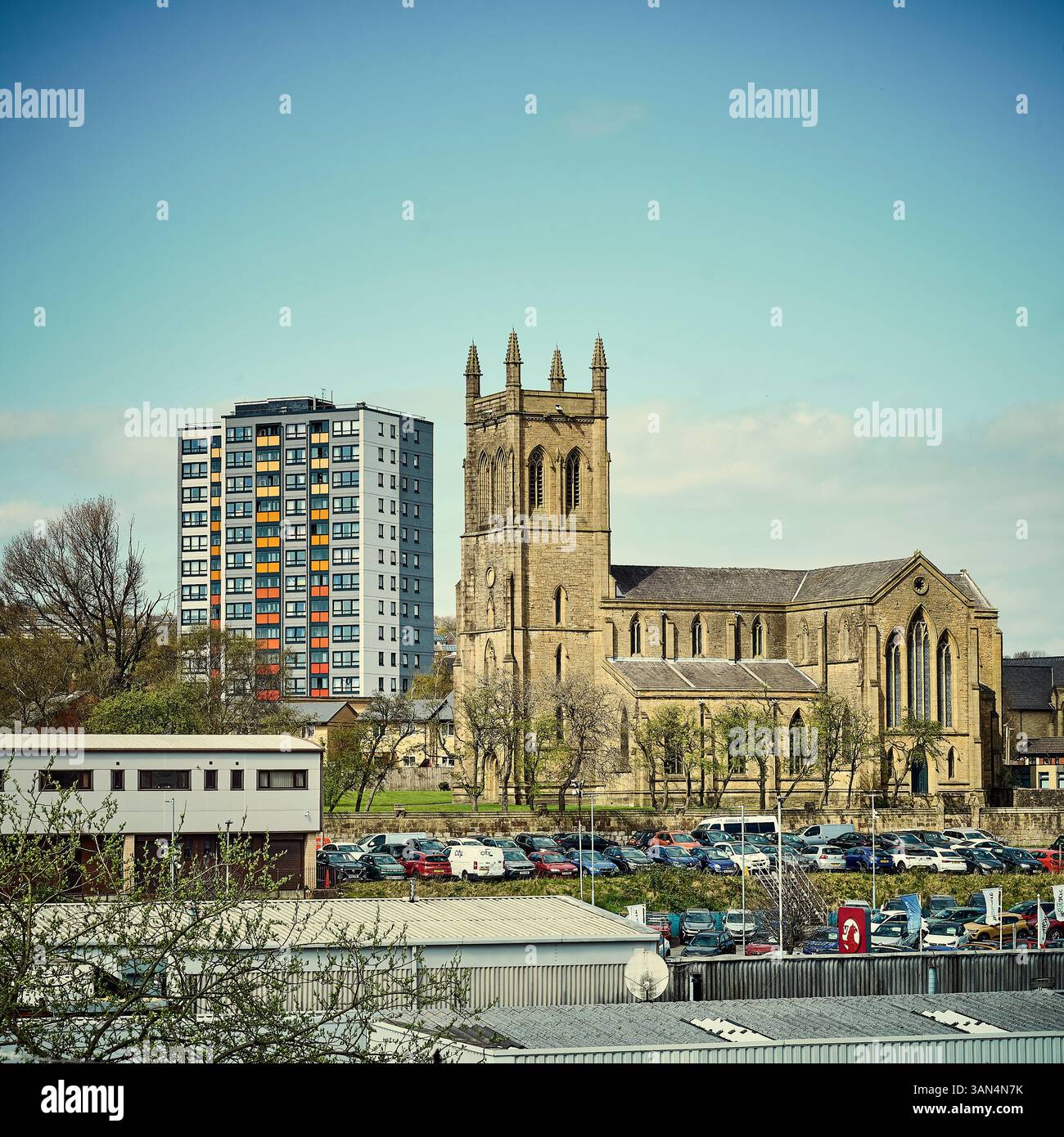 Modern high rise apartment block and old church in Blackburn town ...