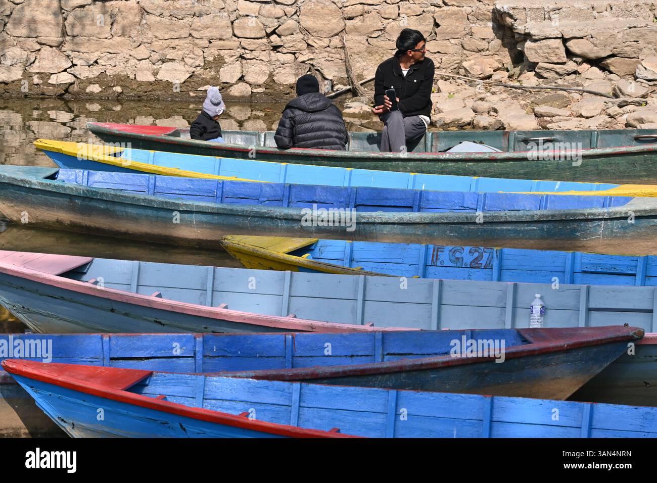 Two boatmen on a colorful boat on lake Phewa, the second largest lake ...