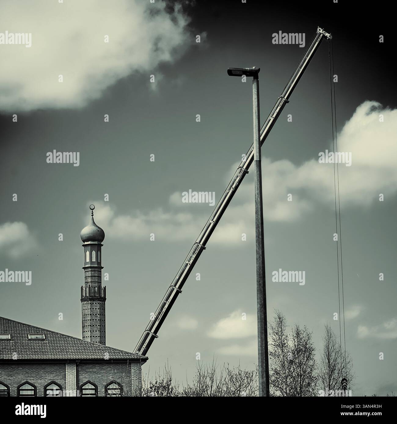 Mosque minaret, crane and lamp post against the sky Stock Photo - Alamy
