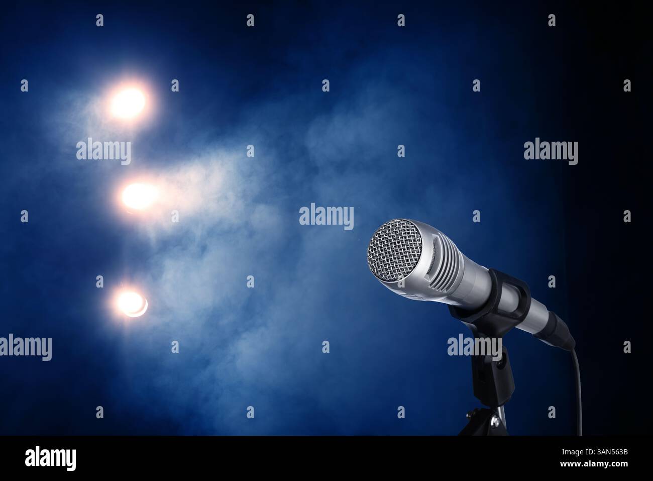 Microphone on stage in smoke under spotlights. Singer's performance ...