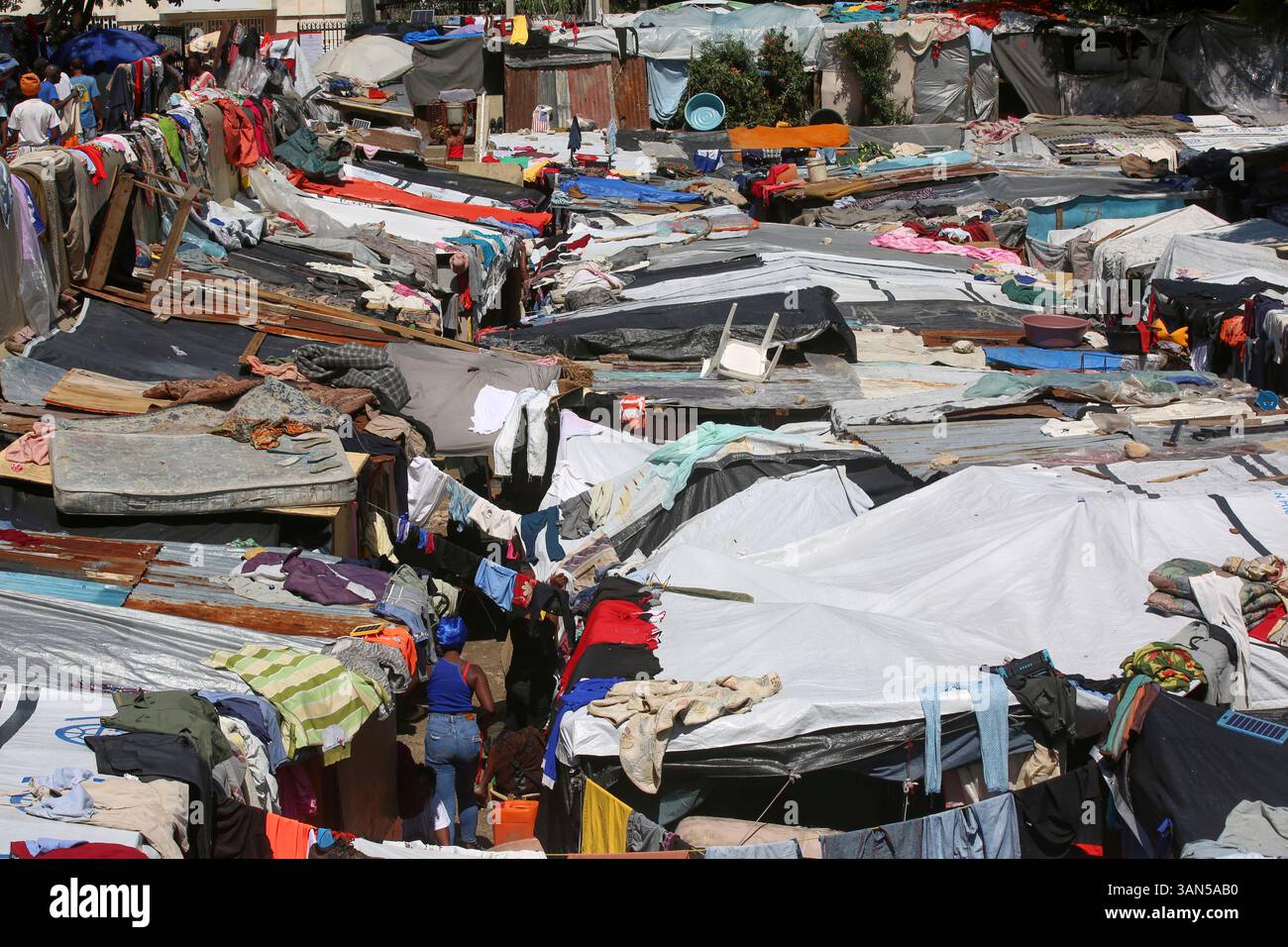 Makeshift tents fill a camp set up by people displaced from their homes ...