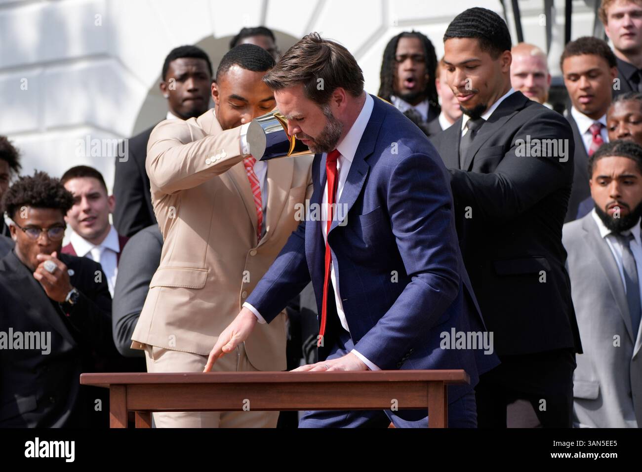 TreVeyon Henderson, left, and Cody Simon grab the top of the trophy as ...