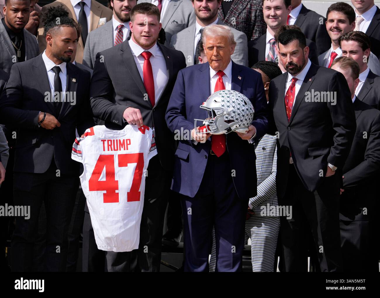 President Donald Trump, second right, poses with a helmet and jersey ...