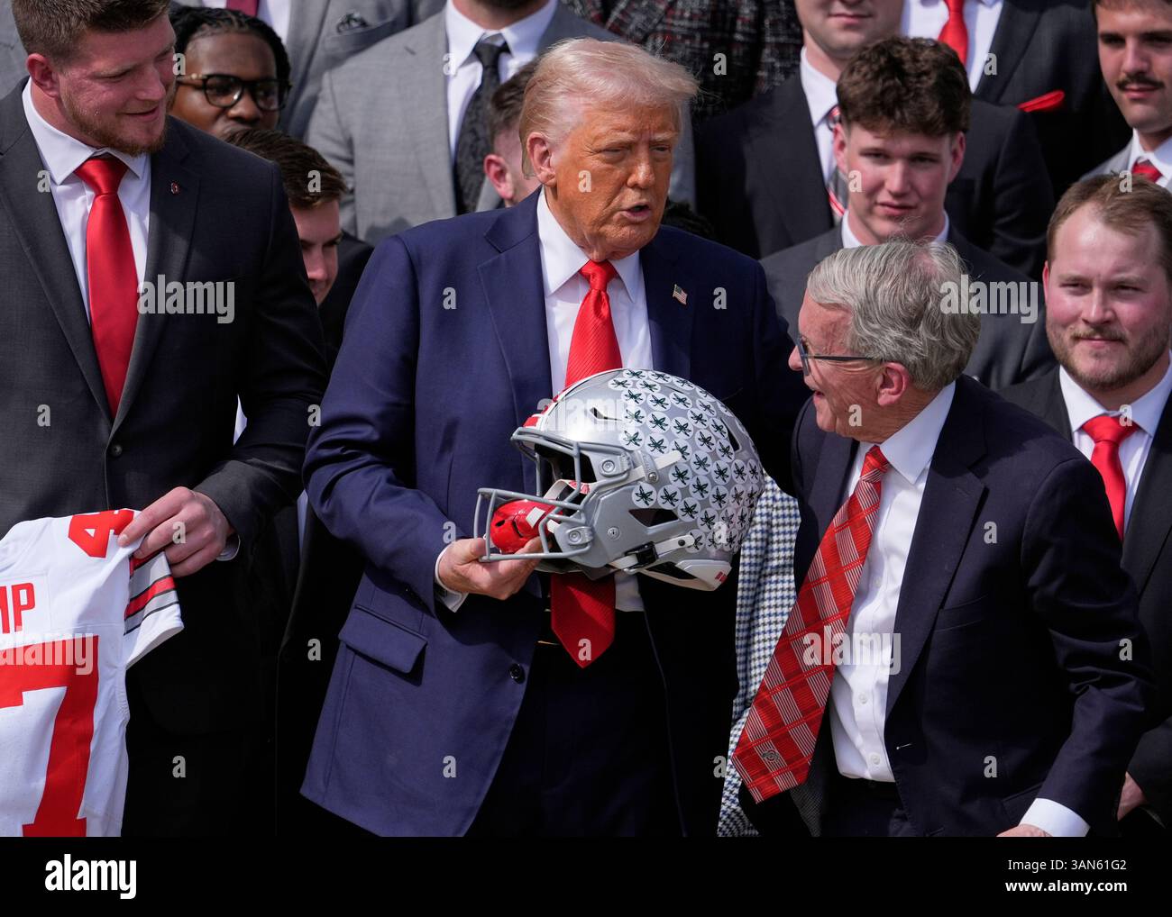 President Donald Trump holds a helmet gifted by the 2025 College ...